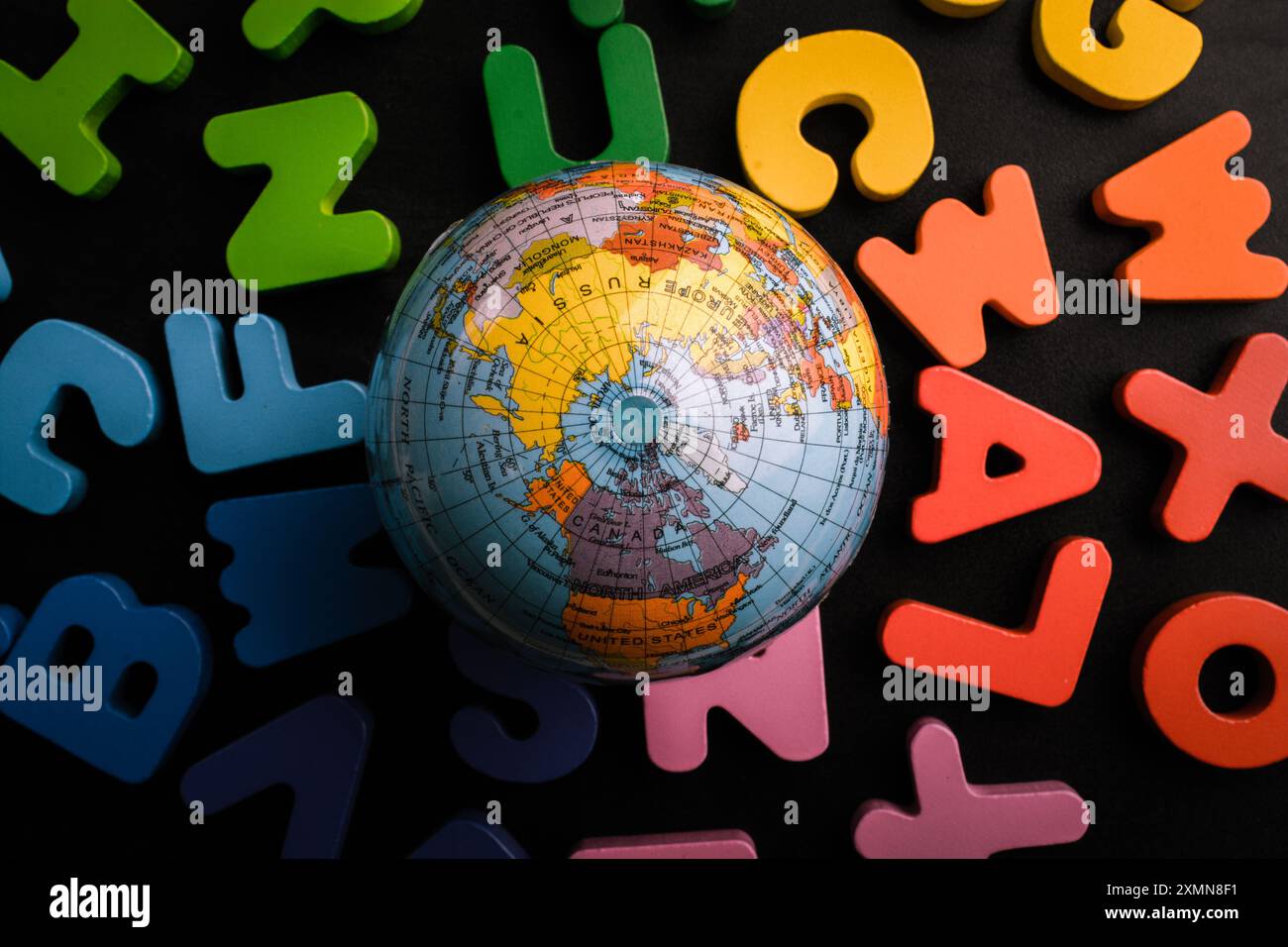 Earth globe model on colorful letters on a black background Stock Photo ...
