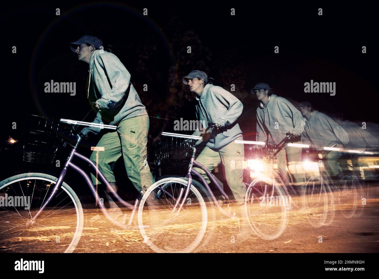 Young woman riding a bicycle at night (Multiple Strobes, Blurred Motion ...