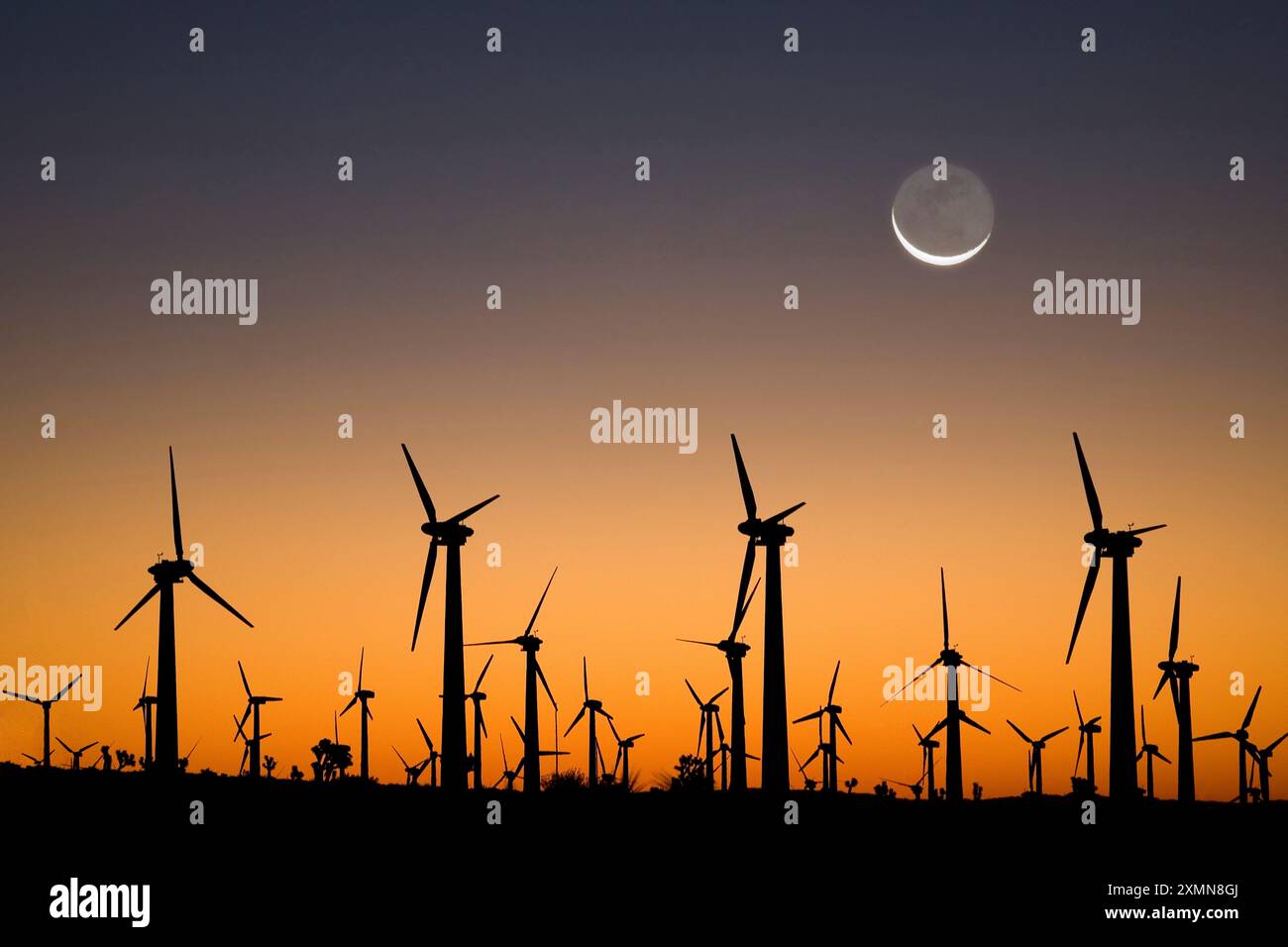 Wind turbines at sunrise with moon Stock Photo - Alamy