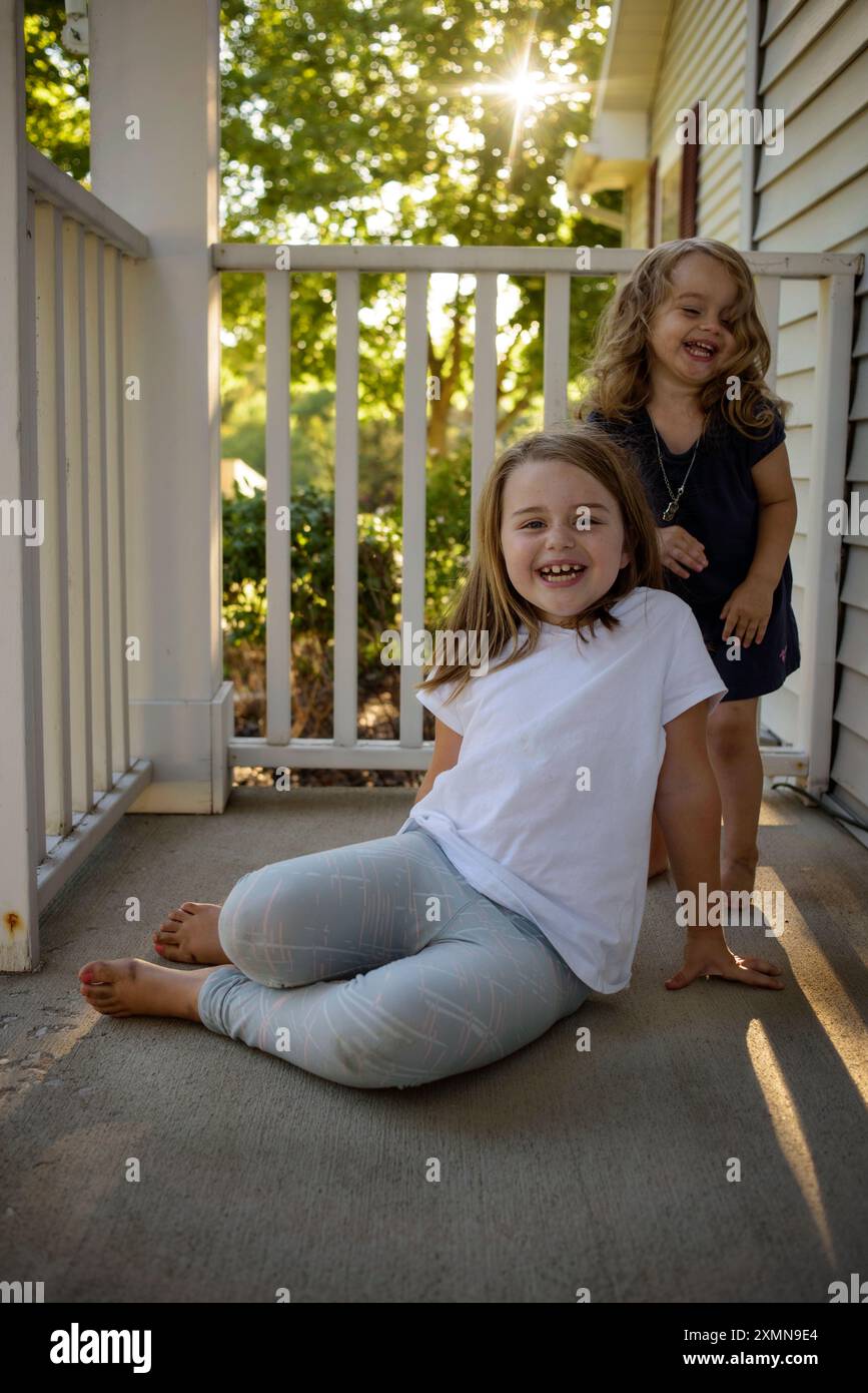 Young sisters laughing together on sunny summer evening Stock Photo - Alamy