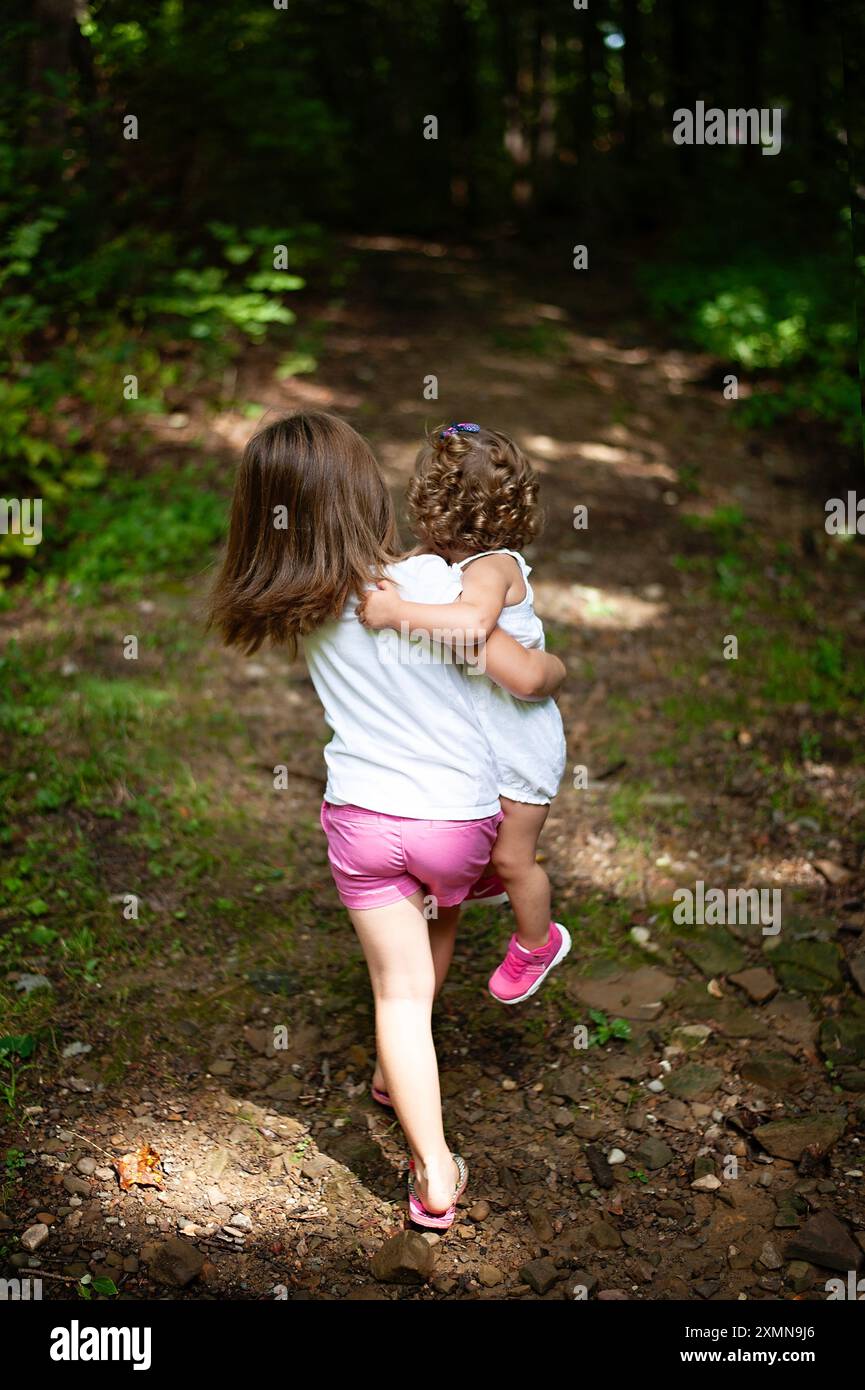 Big sister carrying young sibling down wooded path Stock Photo - Alamy Big sister carrying young sibling down wooded path Stock Photo - Alamy