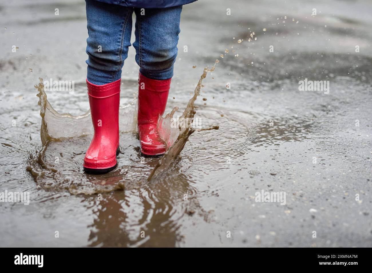 Kid child jumping puddle water splash hi-res stock photography and ...