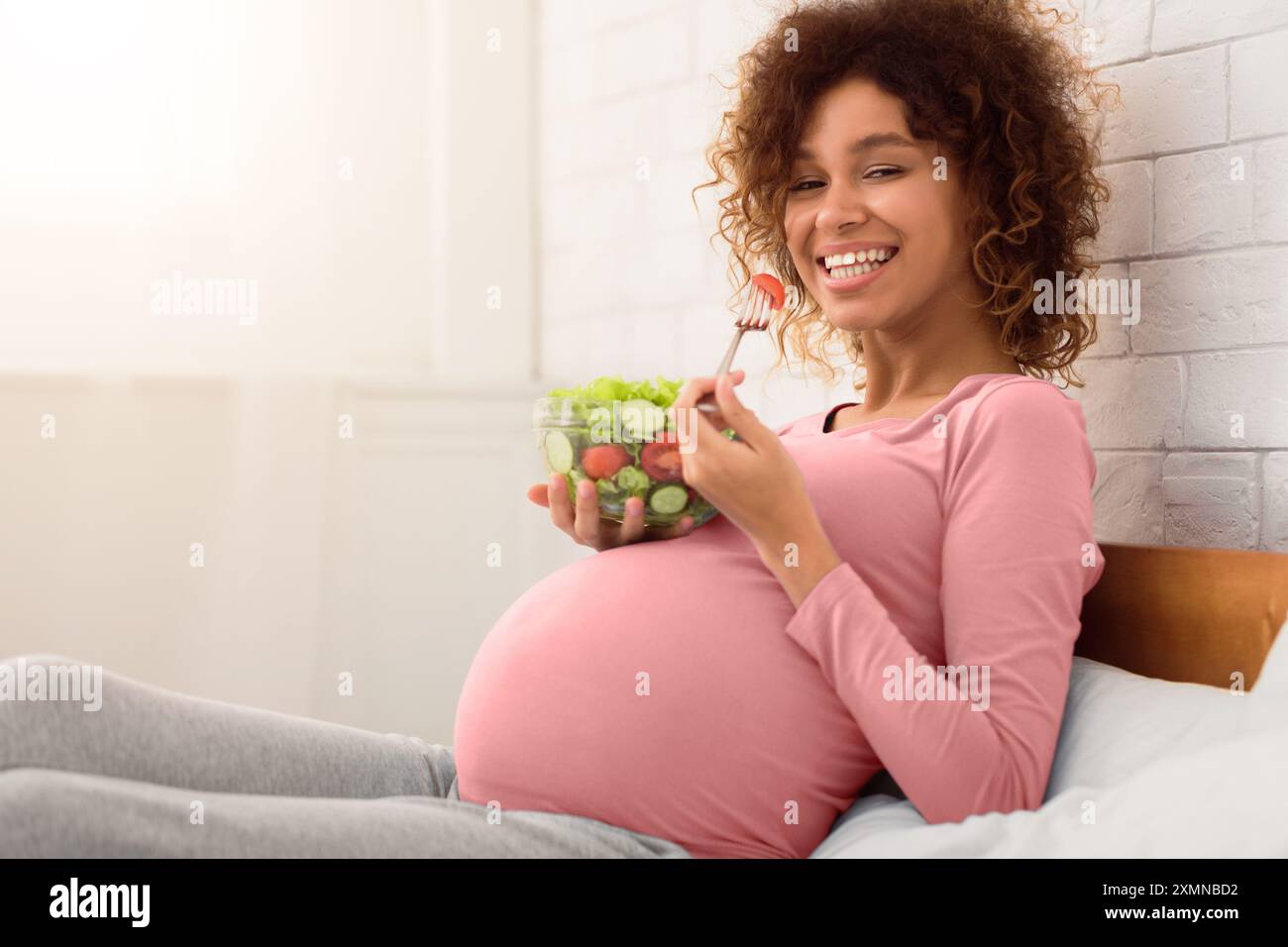 Healthy snack. Afro expectant girl enjoying fresh vegetable salad Stock ...