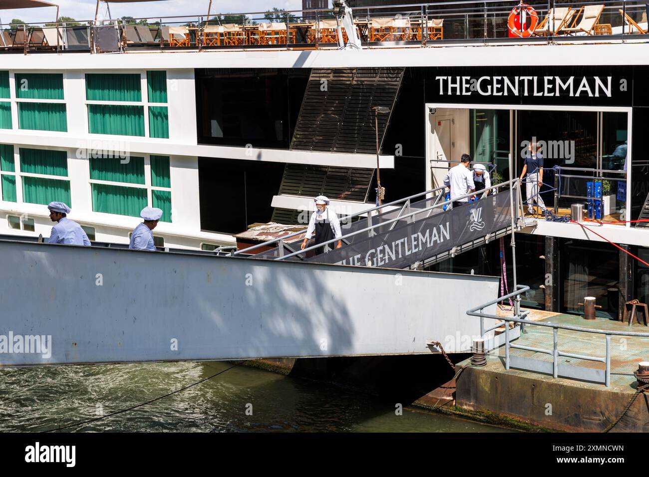 chefs of the cruise ship The Gentleman carry goods over the jetty on ...