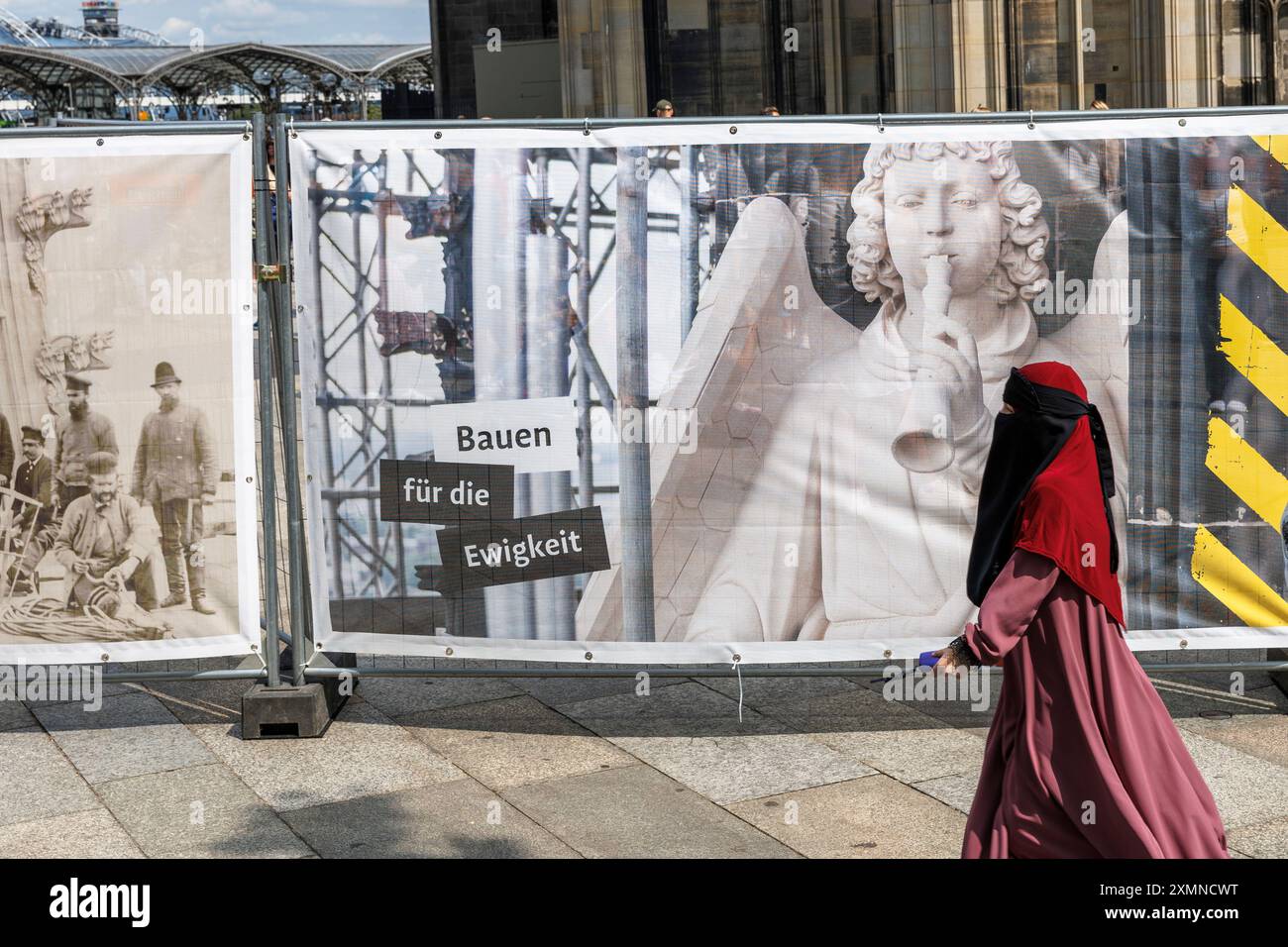 muslim woman dressed in a niqab passes a construction site fence at the ...