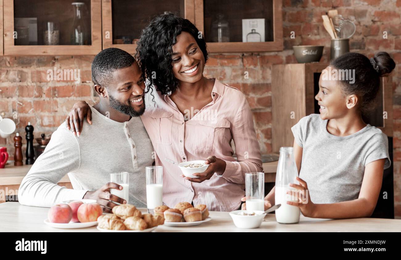 Adorable black family of three having breakfast at kitchen Stock Photo ...