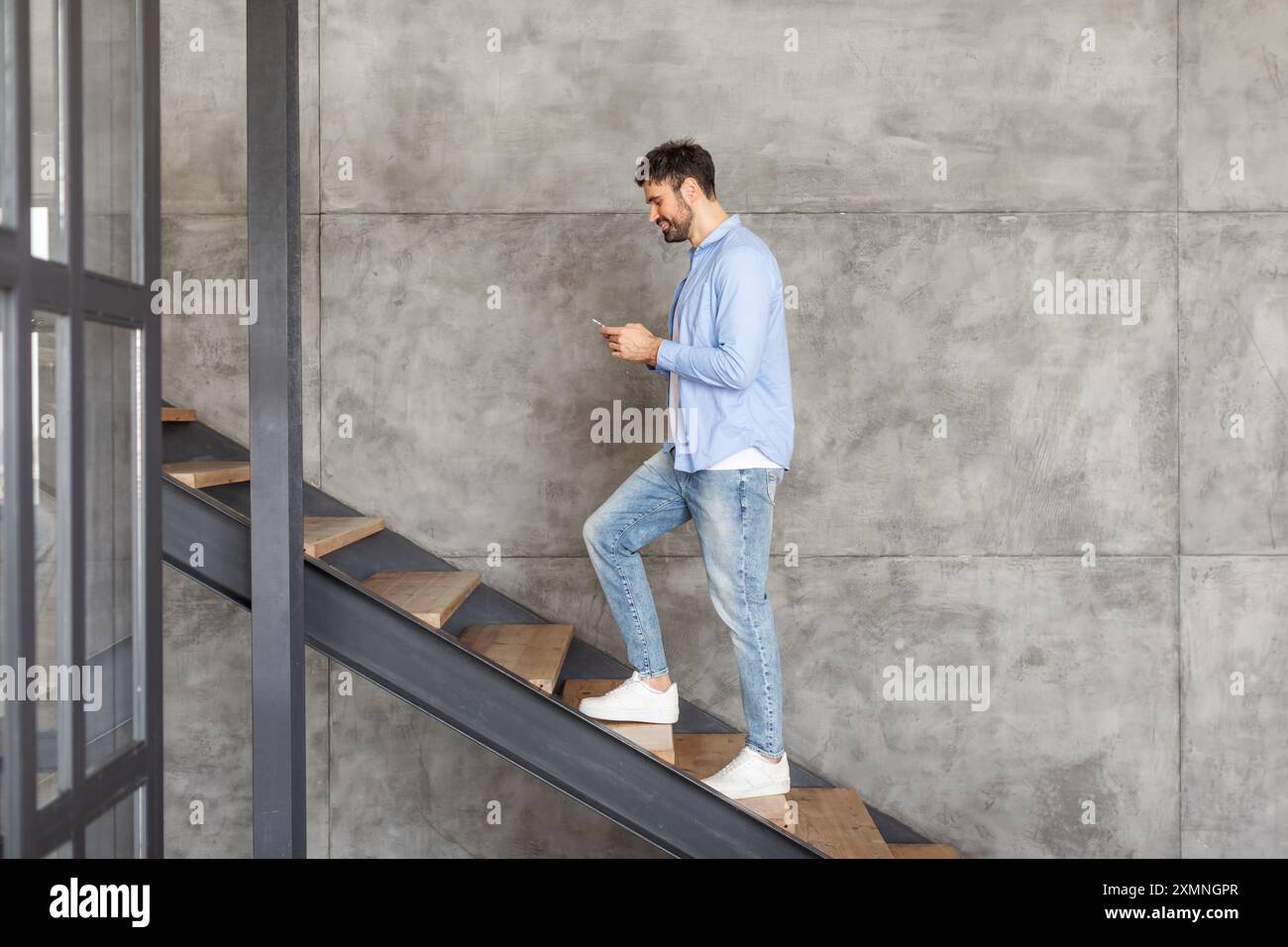 Man Ascending Concrete Staircase While Using Smartphone Stock Photo - Alamy