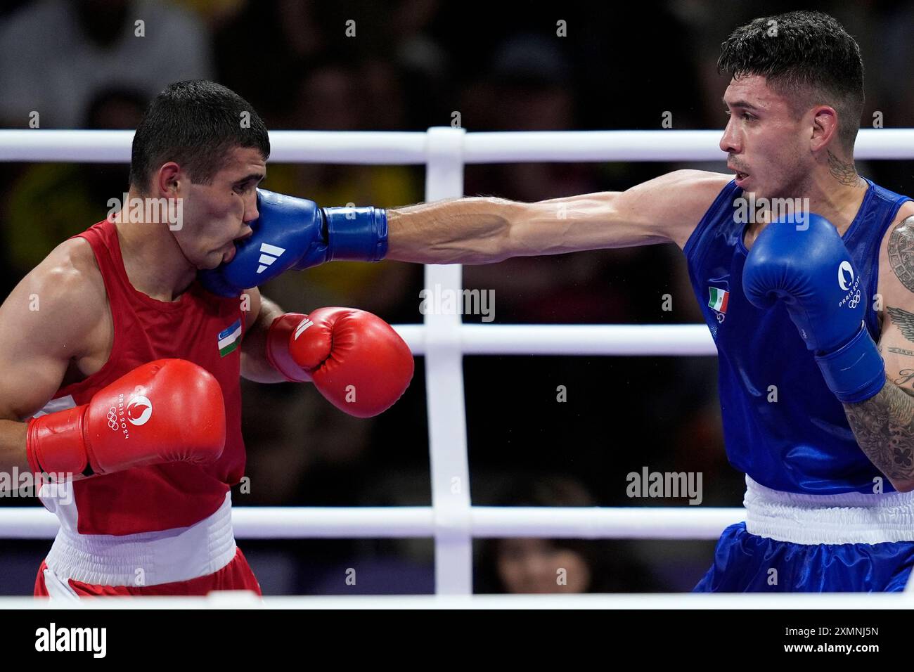 Mexico's Miguel Angel Martinez hits Uzbekistan's Ruslan Abdullaev in their men's 63.5 kg ...