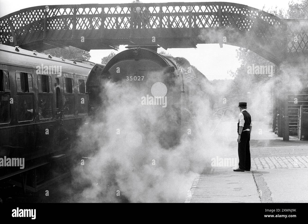 A train guard on the platform at Sheffield Park at the Bluebell Railway ...