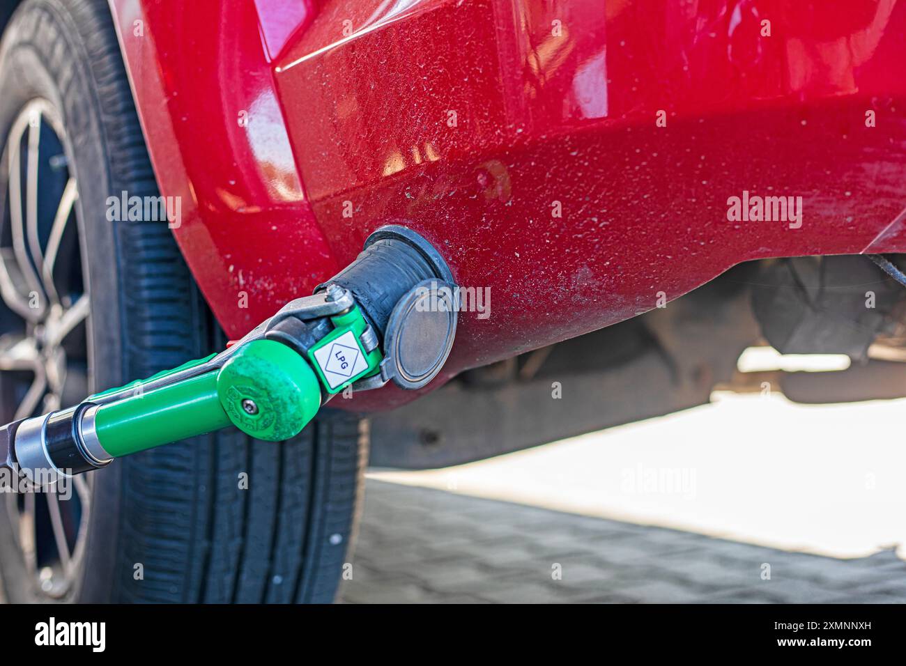filling up a red car with LPG at a universal gas station. Economic ...