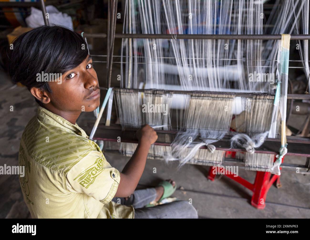 Young bangladeshi man working in a extile factory looms, Dhaka Division ...