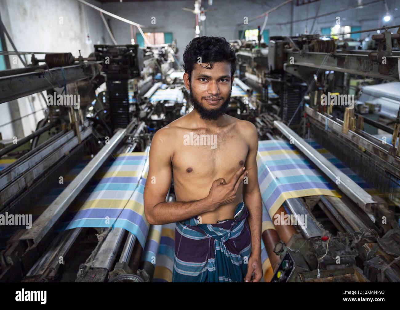 Bangladeshi man working in a extile factory looms, Dhaka Division ...