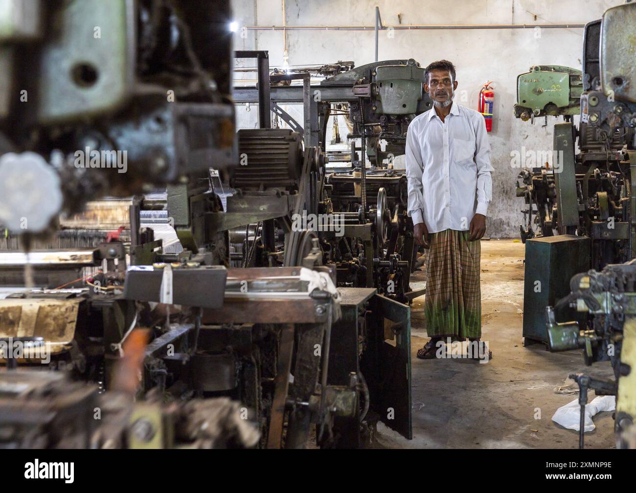 Bangladeshi man working in a extile factory looms, Dhaka Division ...