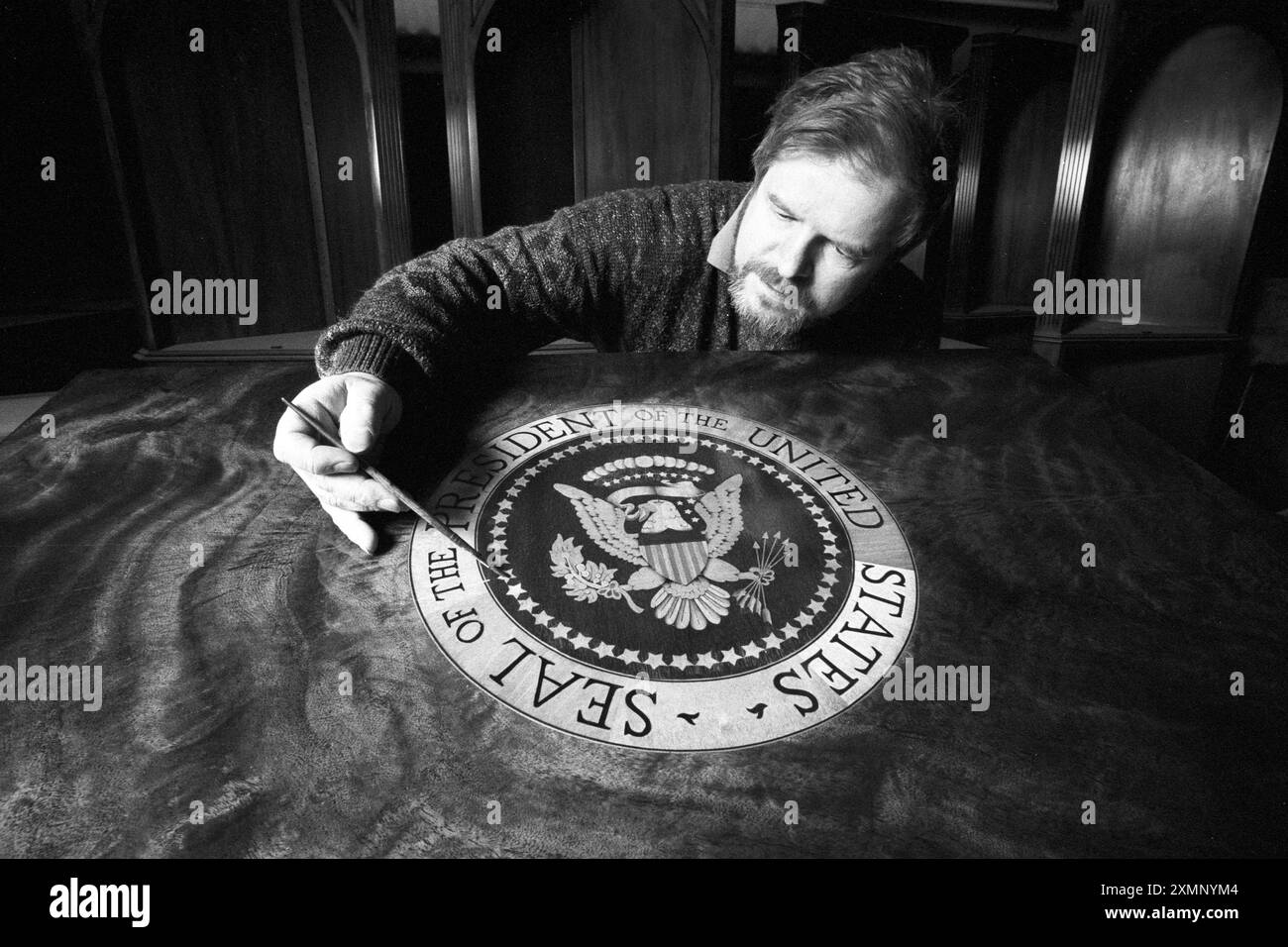 Artist at work on Bill Clinton 's table with the Presidential seal ...