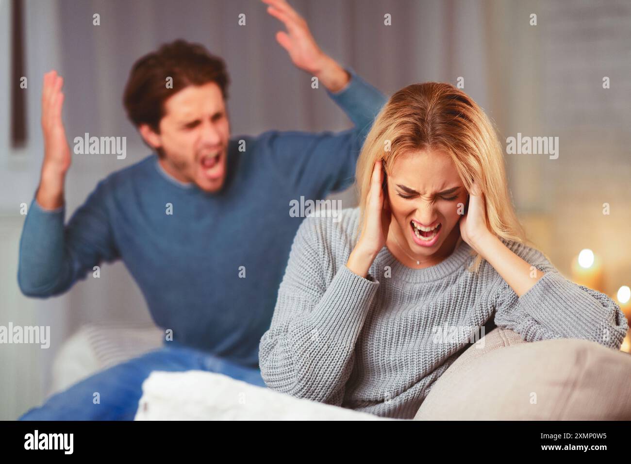 Aggressive Man Shouting At Woman Sitting On Sofa At Home Stock Photo ...