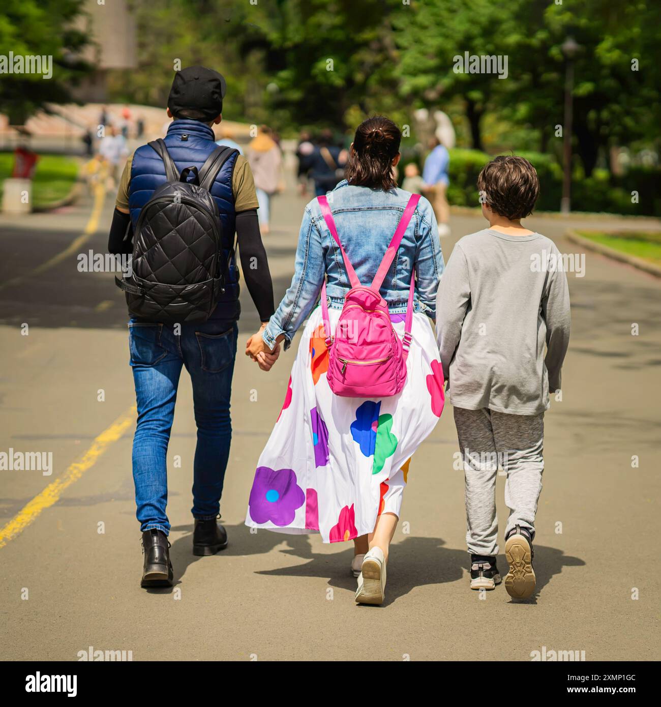 Friendly family, parents and son walk in park, holding hands. Concept ...