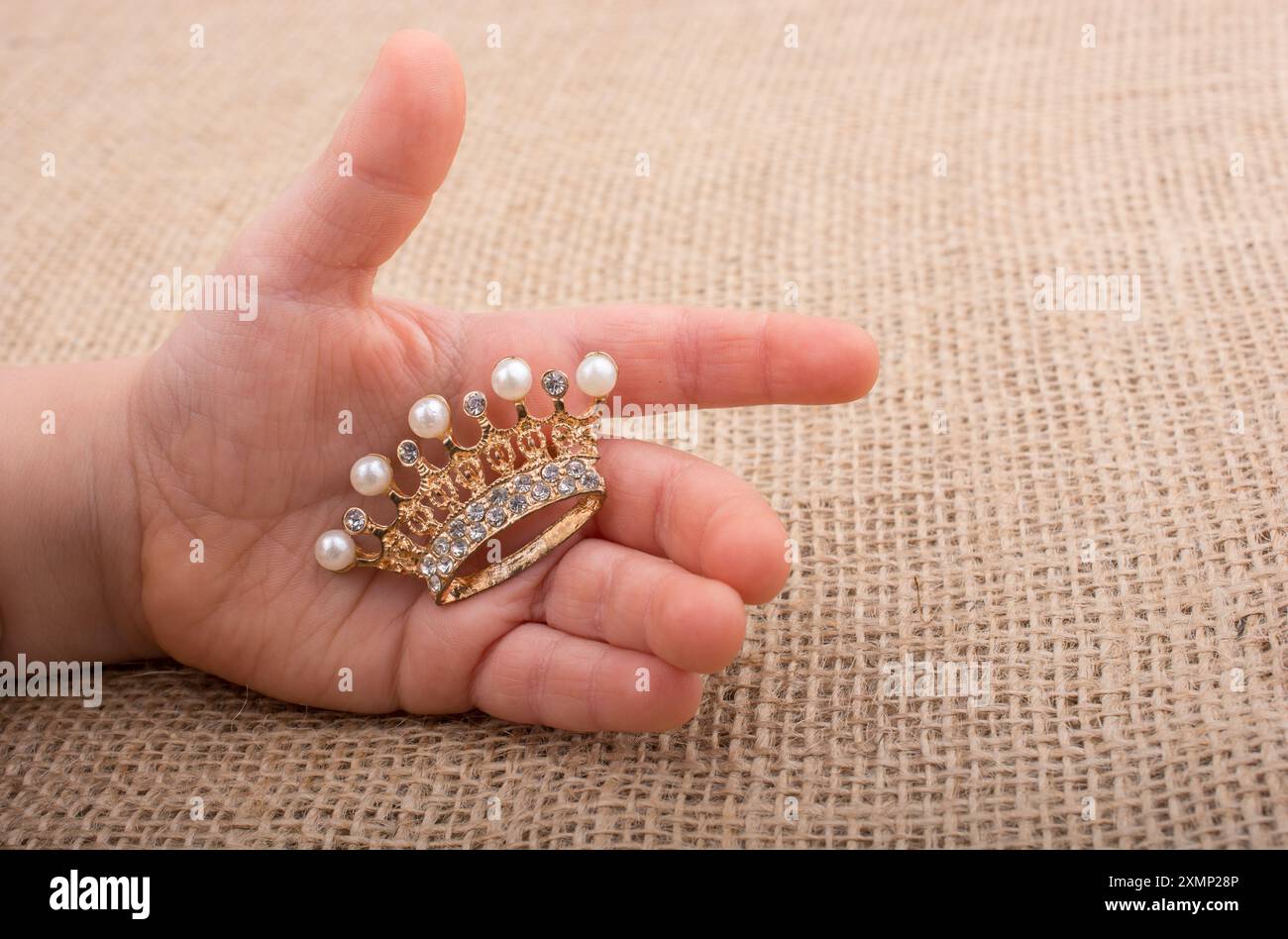 Hand holding a little model crown in hand Stock Photo - Alamy