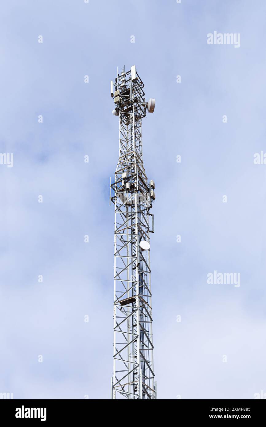 A tall telecommunication tower antenna in a sky with clouds Stock Photo - Alamy