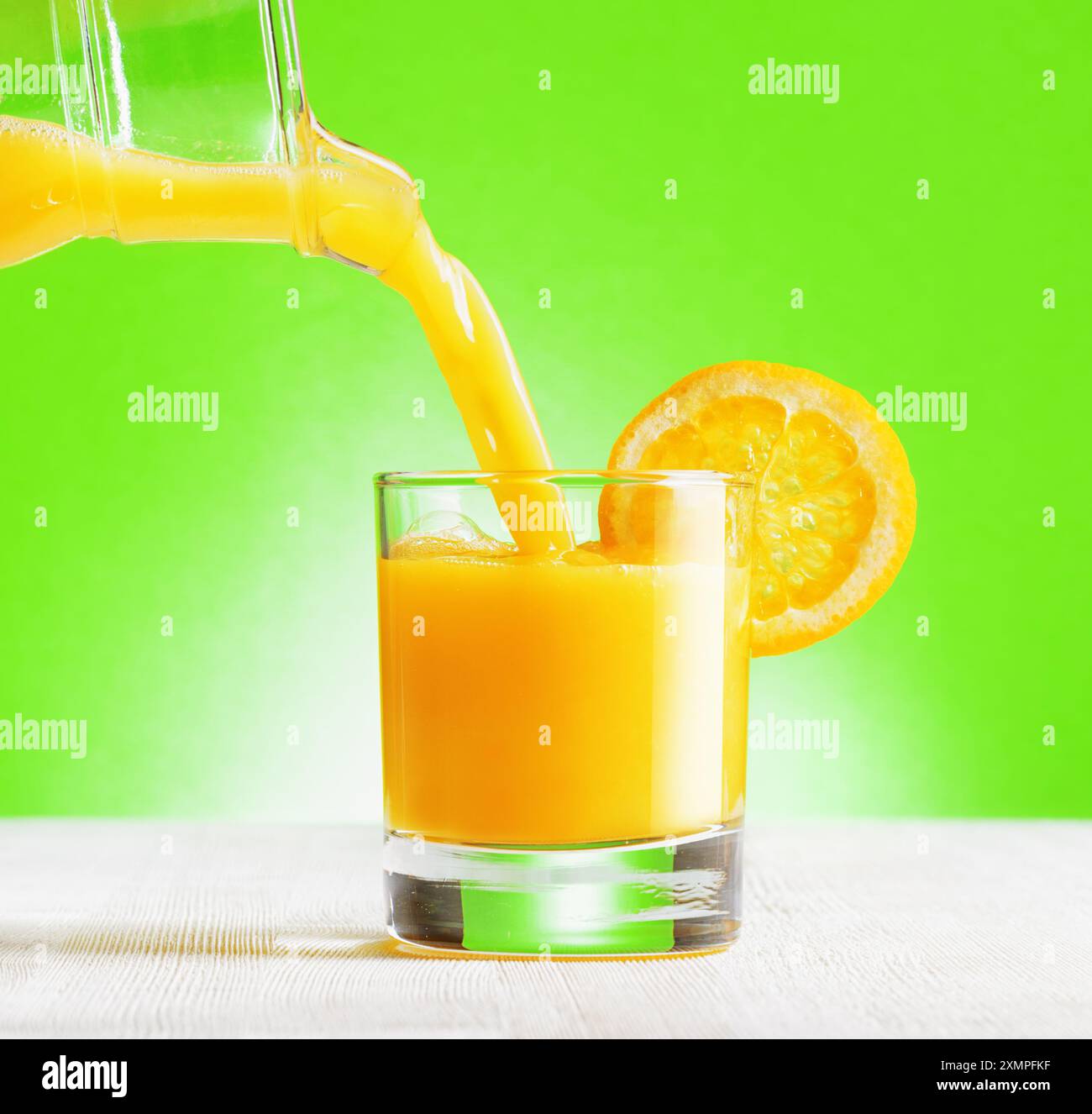 Orange juice pouring from jug into a glass Stock Photo - Alamy