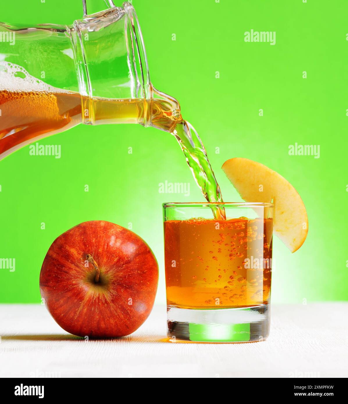 Apple juice pouring from jug into a glass Stock Photo - Alamy