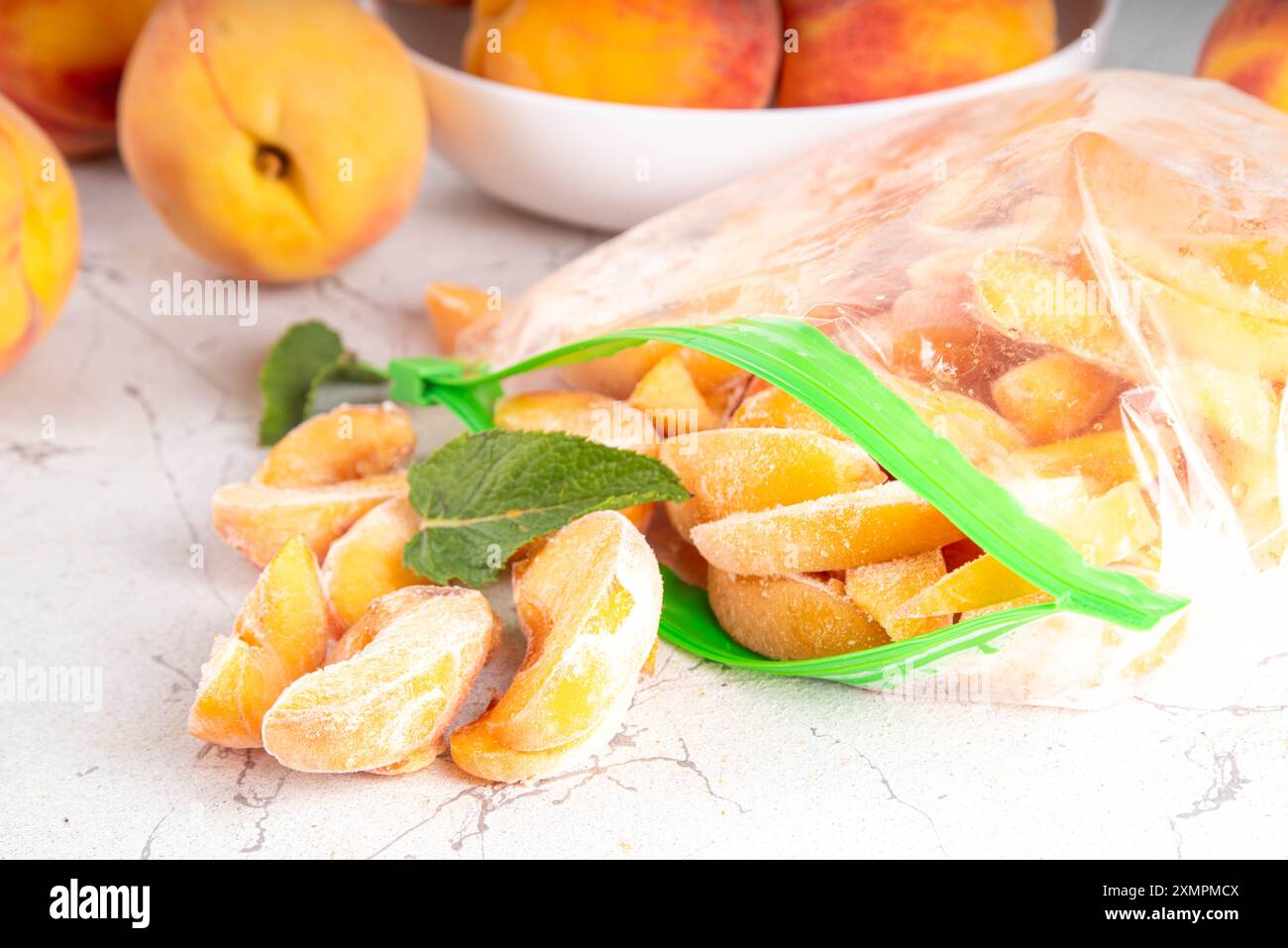 Frozen peaches in freezing bags with fresh ripe raw peach fruits on ...