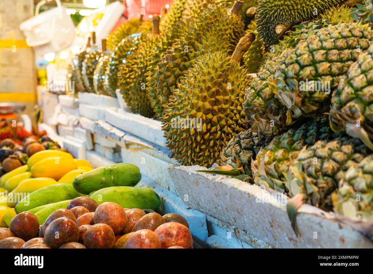Variety of fresh tropical fruits displayed at a market stall. Colorful ...