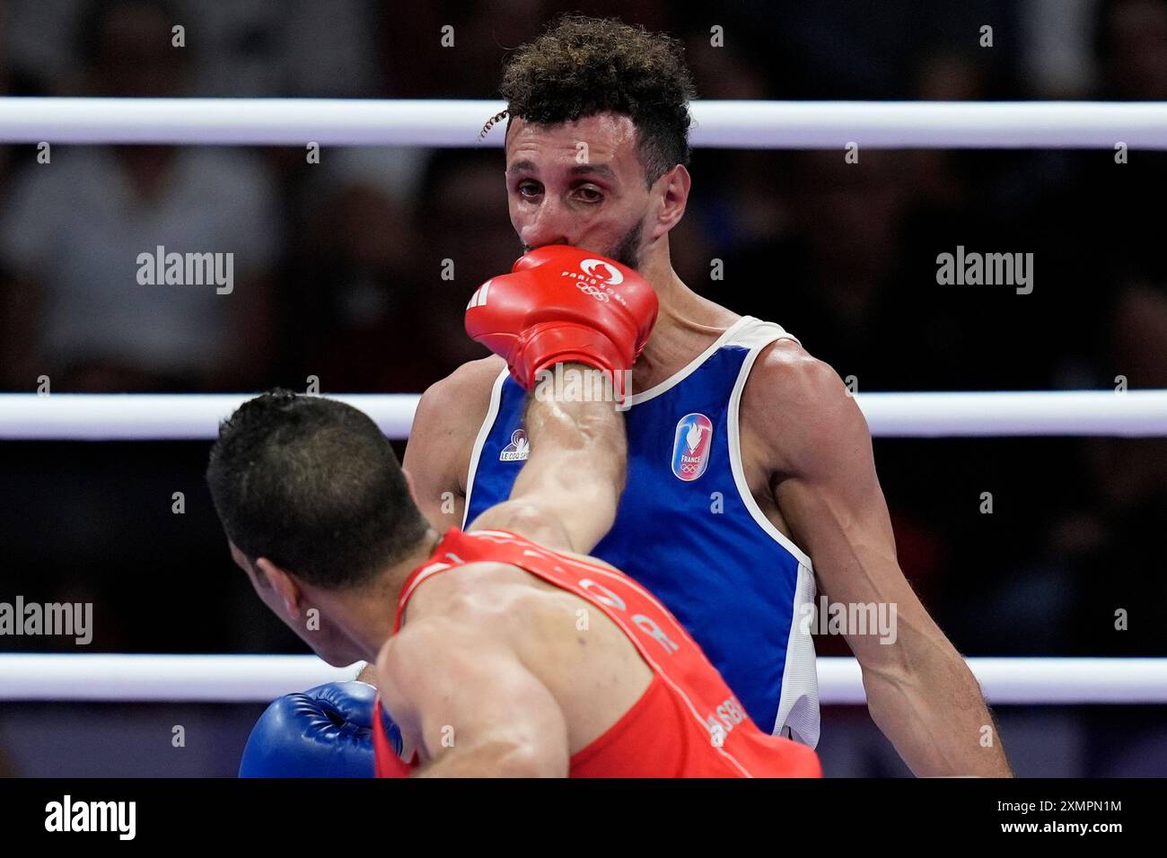 Jordan's Obada Alkasbeh hits France's Sofiane Oumiha in their men's 63. ...
