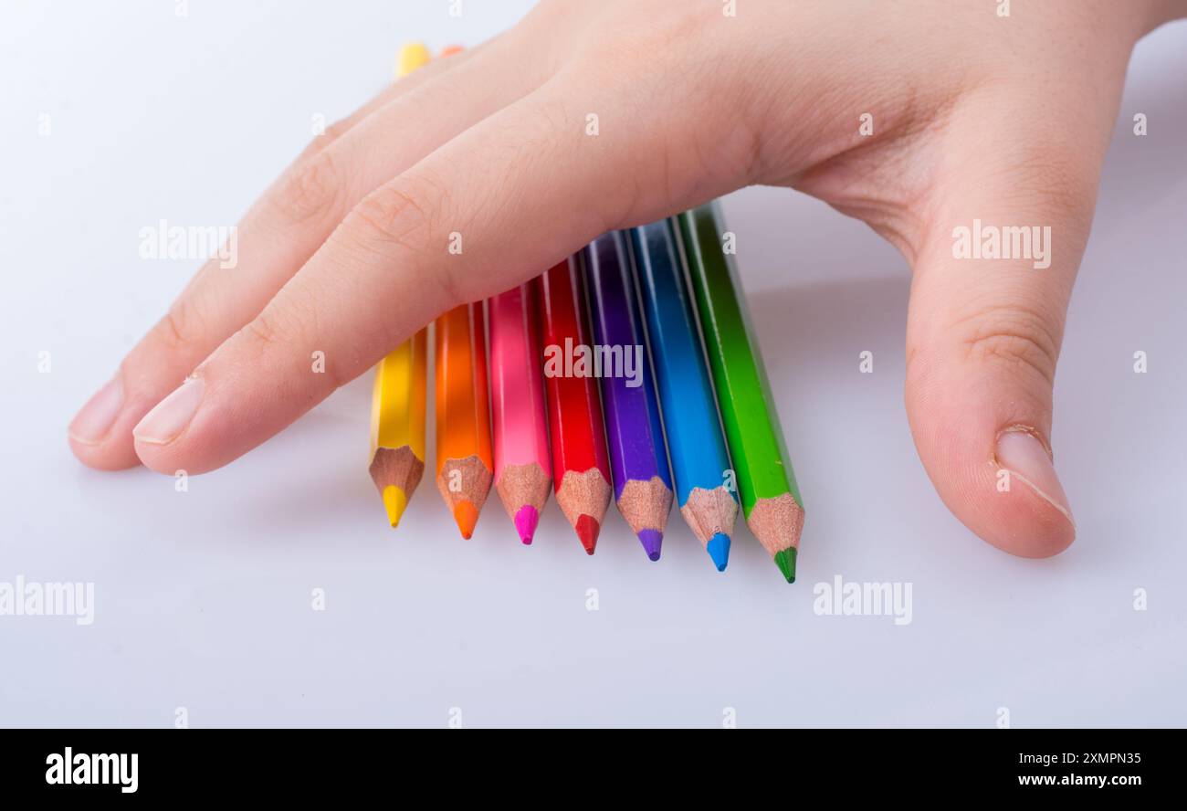 Hand holding color Pencils placed on a white background Stock Photo - Alamy