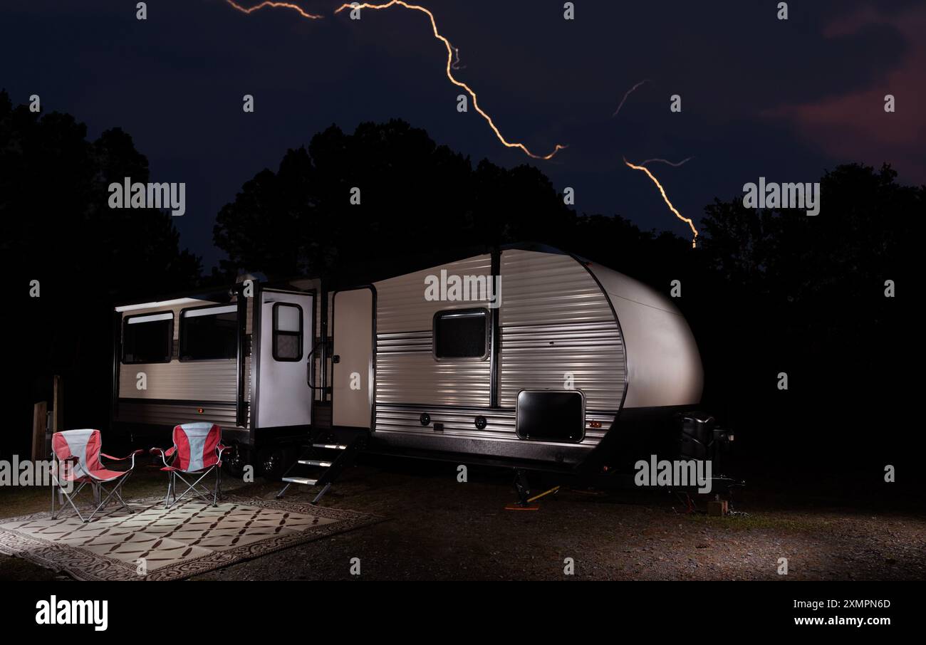 Travel trailer at night with lighted campsite and a lightning bolt in ...