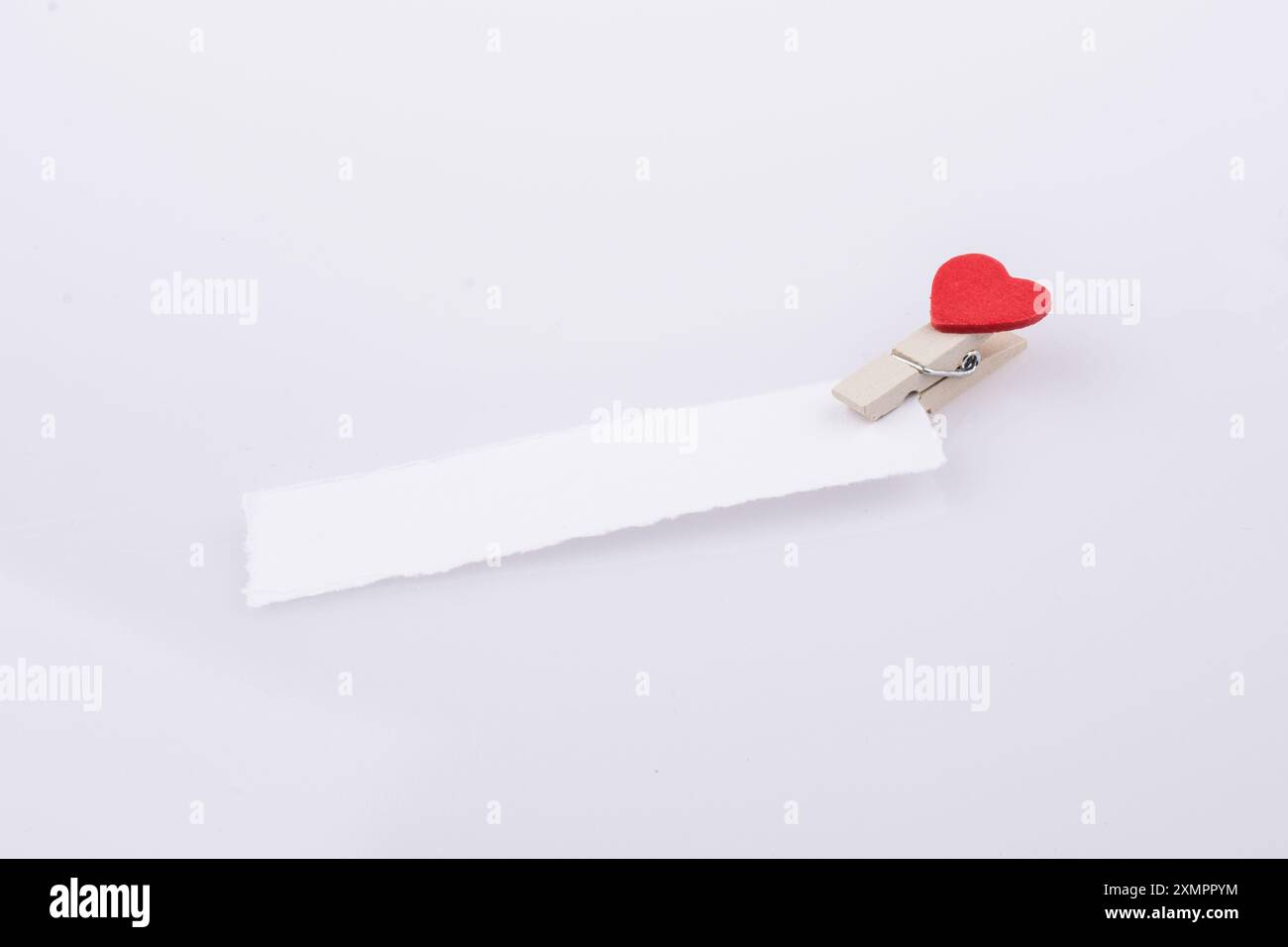 Red hearted clip on an empty torn paper Stock Photo - Alamy