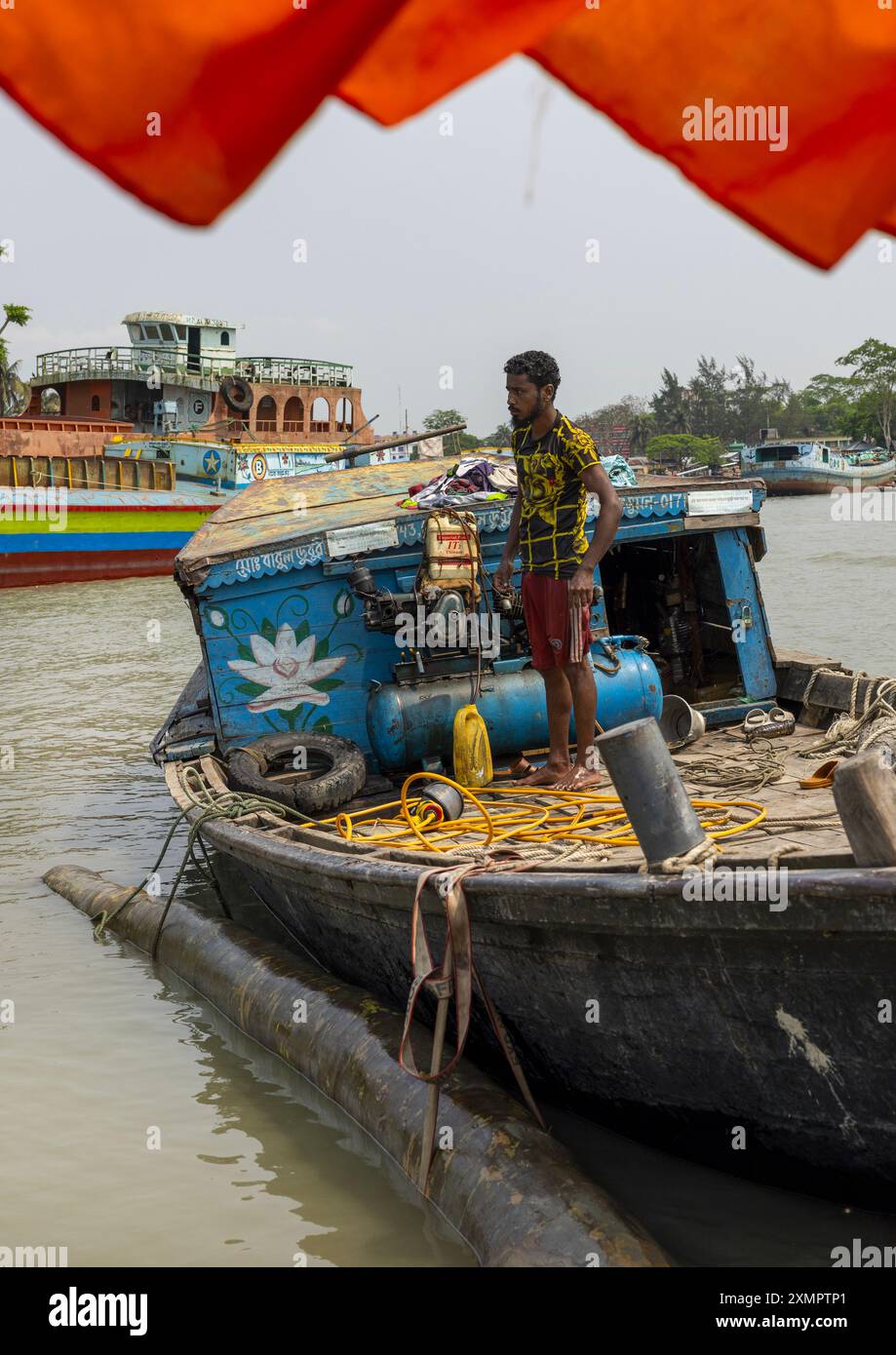 Bangladeshi men attaching a tree trunk to their boat, Barisal Division ...