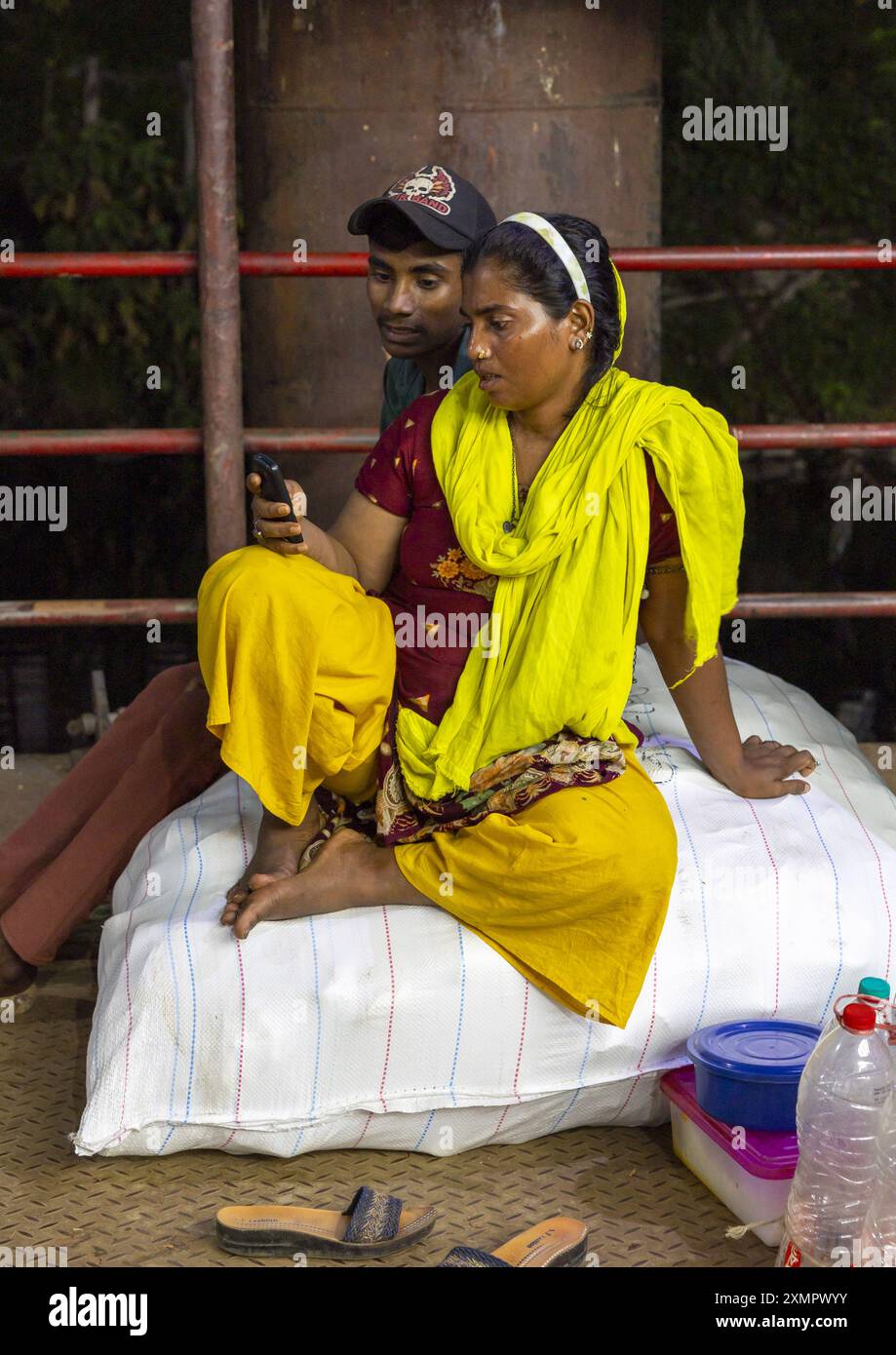 Bangladeshi couple waiting boat at Sadaghat Launch Terminal, Dhaka Division, Dhaka, Bangladesh ...