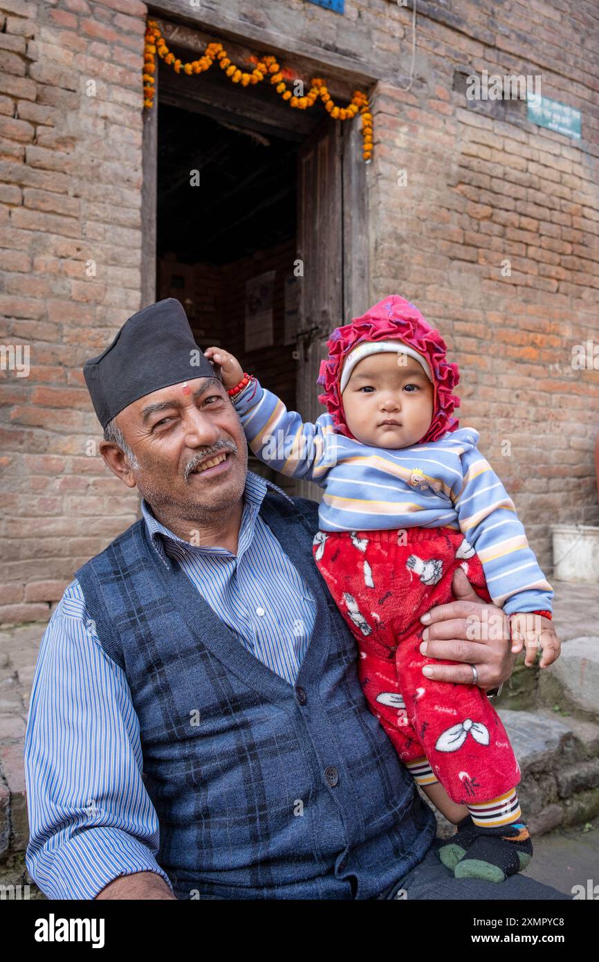 Nepalese grandfather with grand baby wears traditional bhadgaunle topi ...