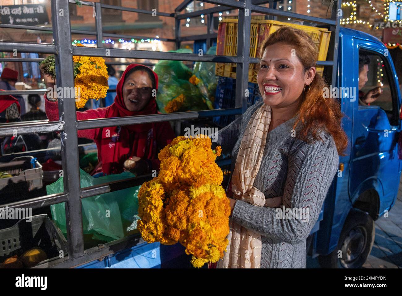 Happy customer buys garland of marigold flowers from street vendor at ...