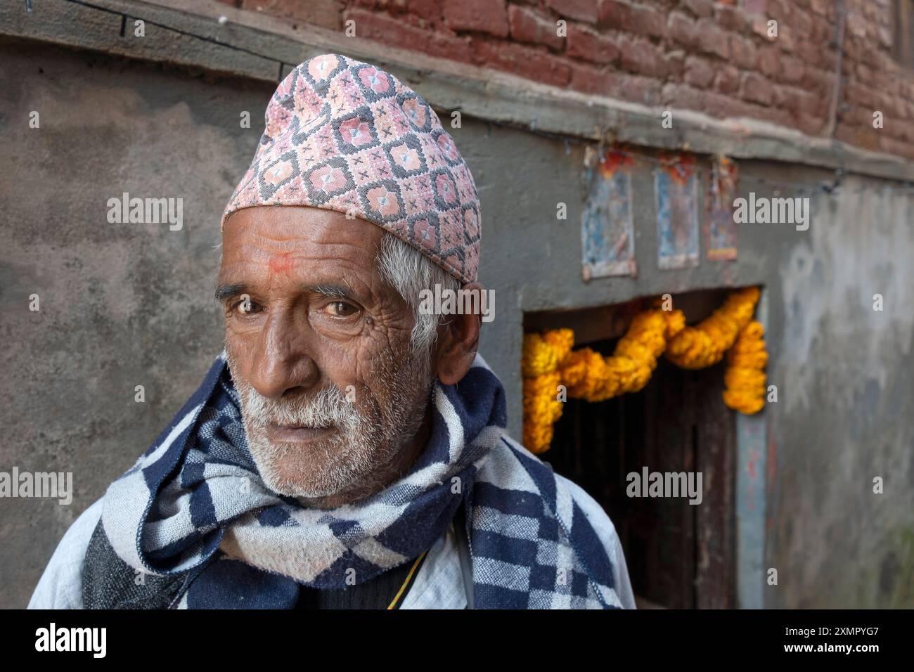 Nepalese gentleman wearing traditional dhaka topi cap outside home with ...