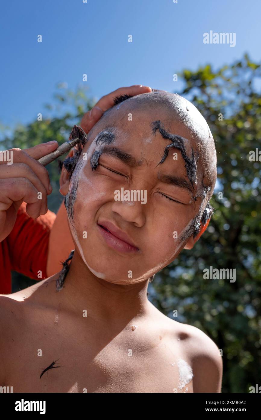 Novice monk has head shaved by older monk at Enchey Monastery, Gantok ...