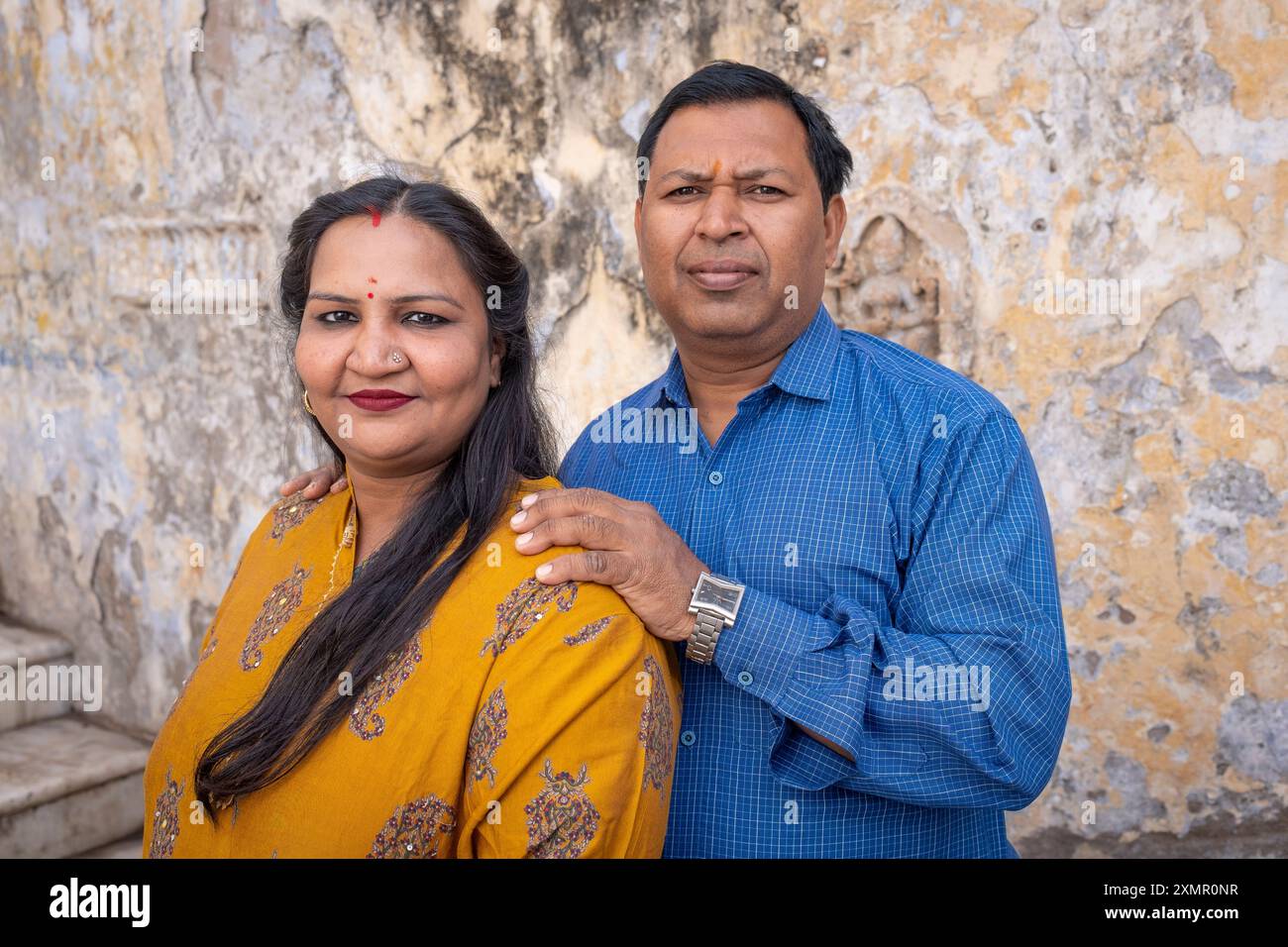 Woman in traditional sari and husband arrives at bathing ghat along ...
