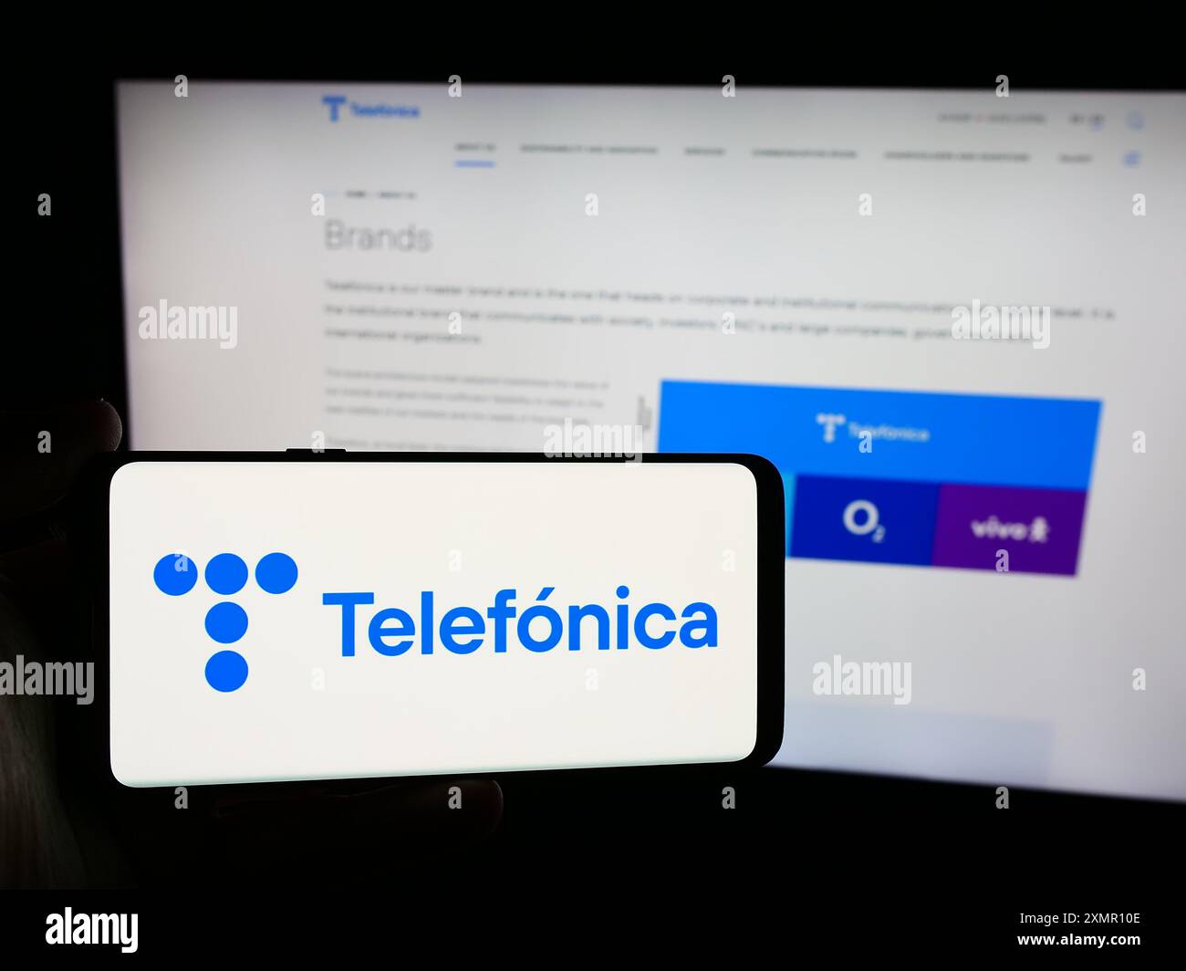 Person holding smartphone with logo of Spanish telecommunications ...