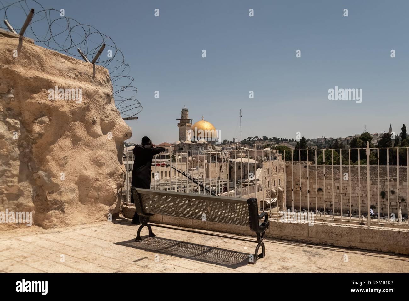 A male Jewish worshipper looks at the Dome of the Rock and the Western ...