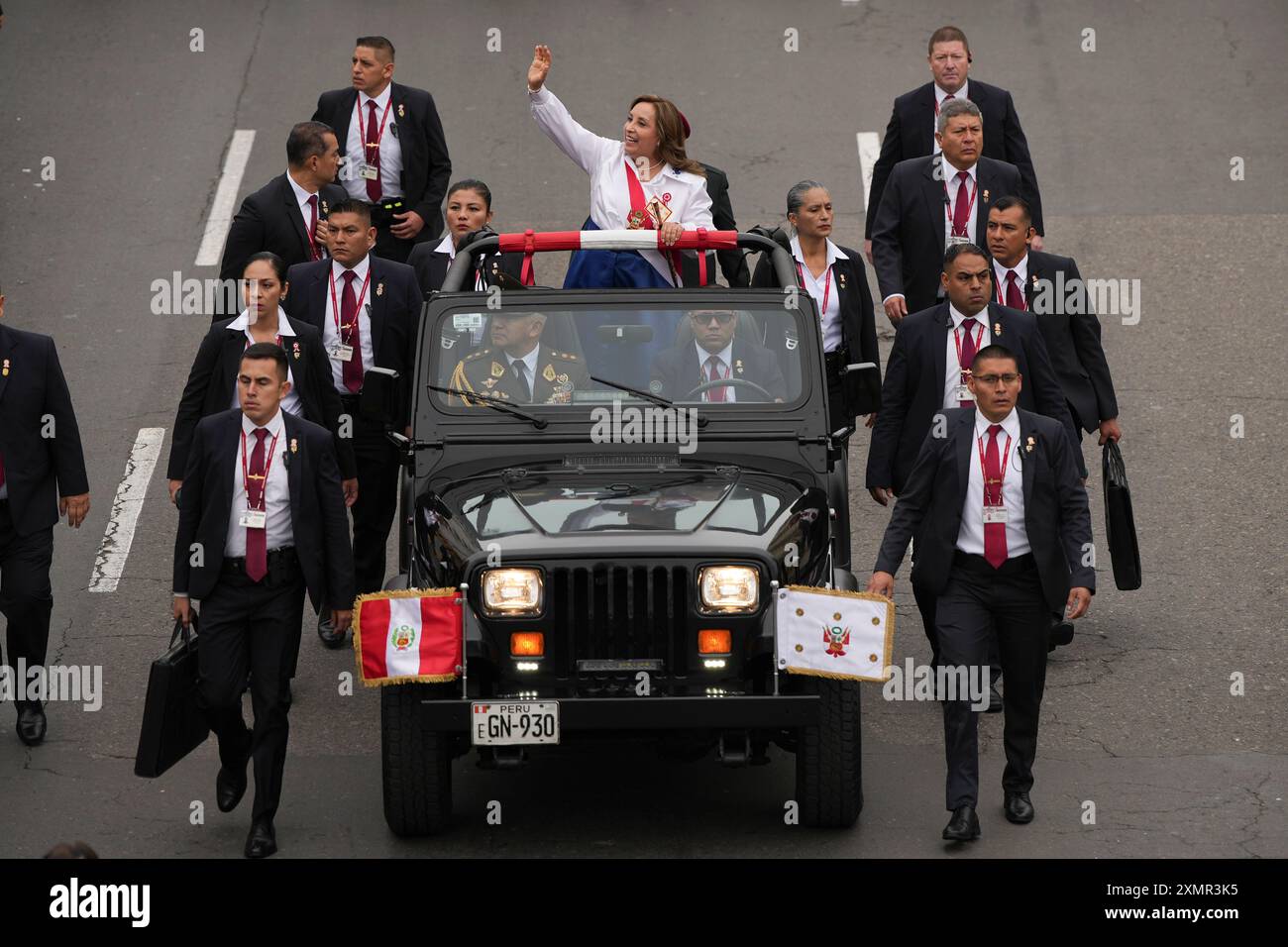 Peruvian President Dina Boluarte is surrounded by security as she waves ...