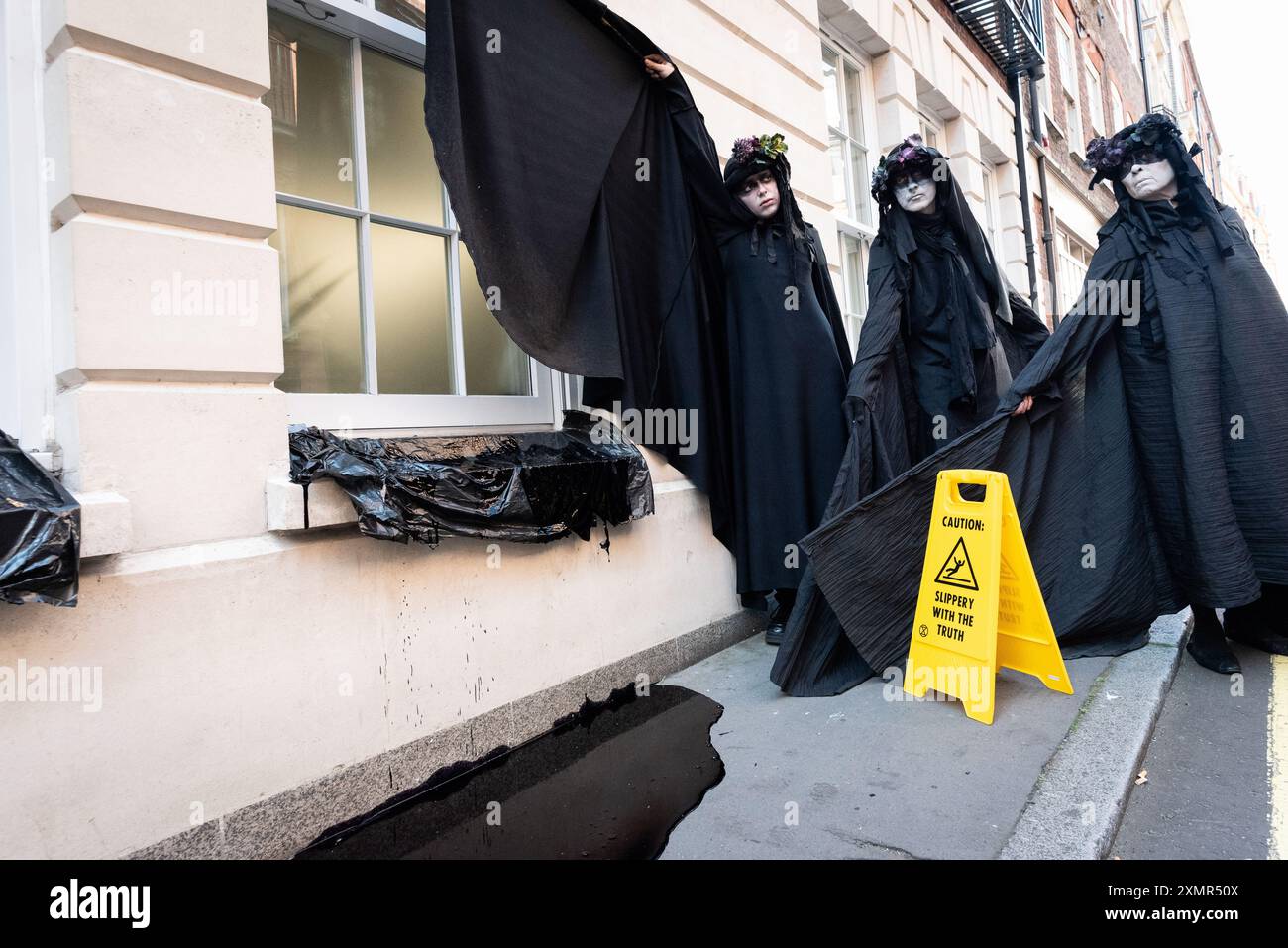London, UK. 29 July, 2024. Activist mime troupe the 'Oil Slickers ...