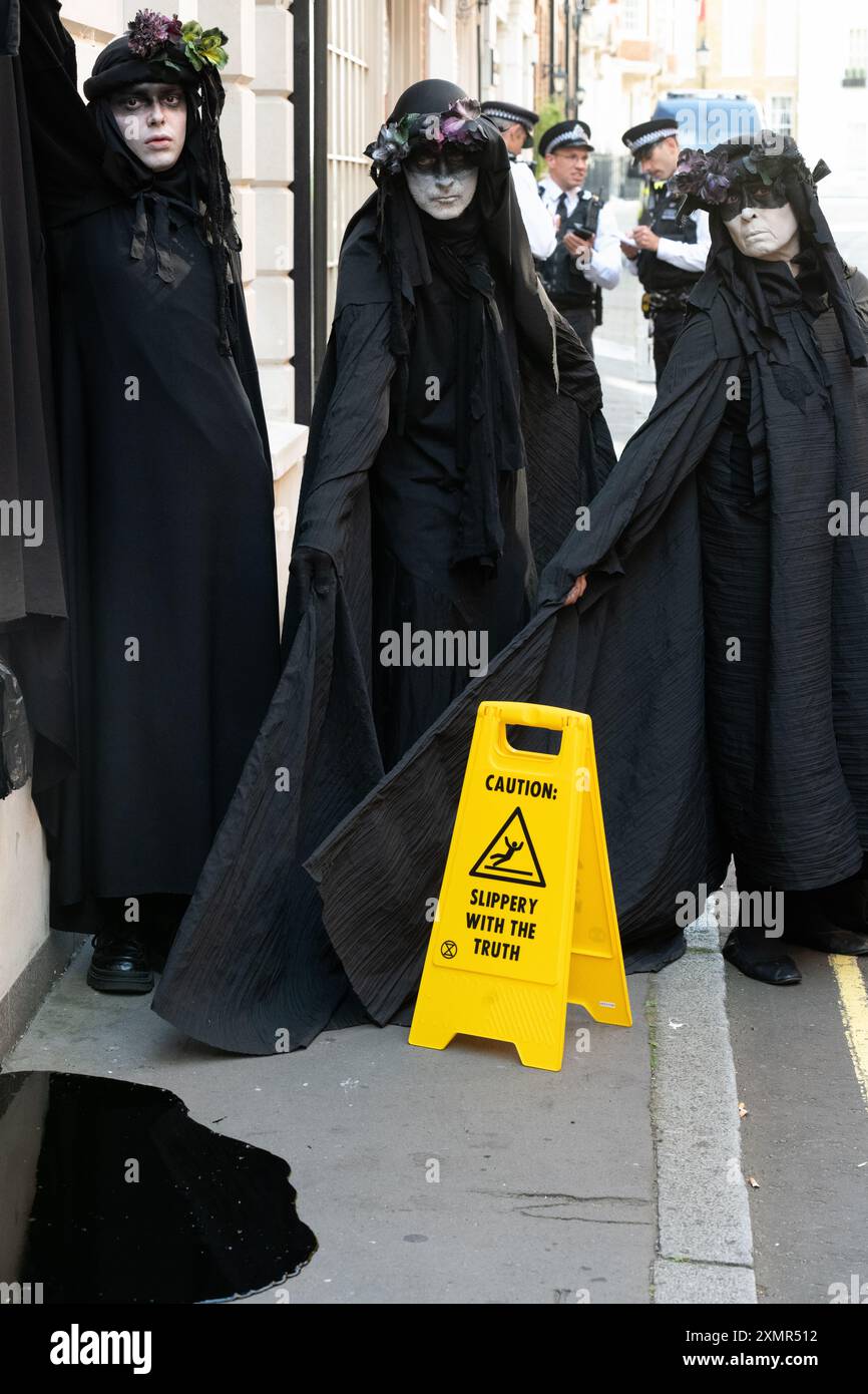 London, UK. 29 July, 2024. Activist mime troupe the 'Oil Slickers ...