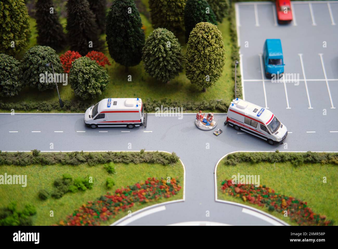Model of ambulances on road next to miniature paramedics with patient ...