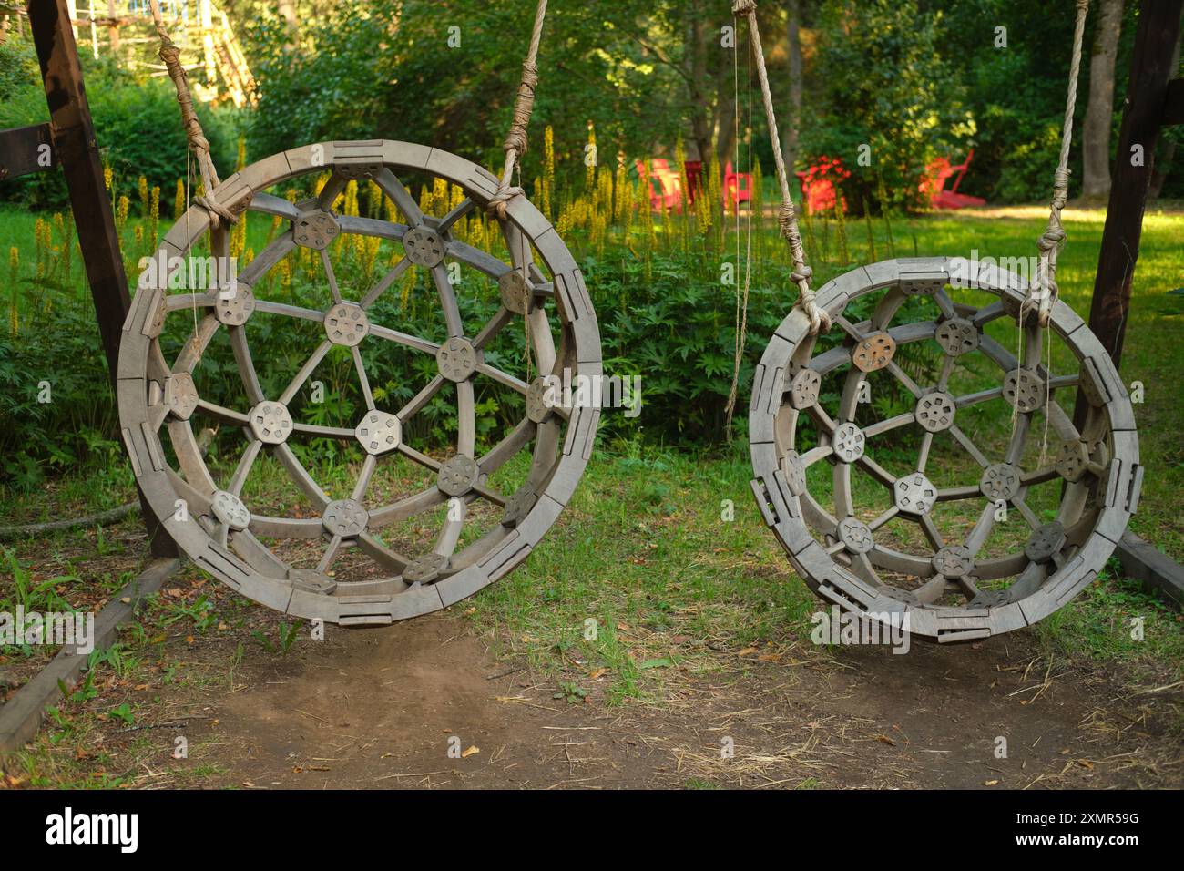 Two wooden geometric swings in a green park. Outdoor playground ...