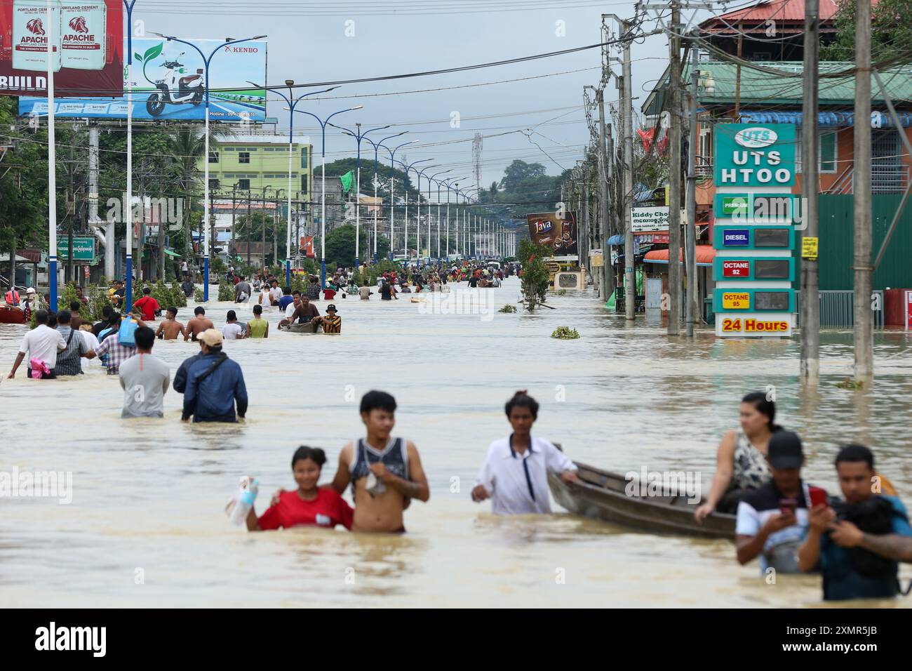 Bago. 29th July, 2024. People wade through a flooded area in Bago ...