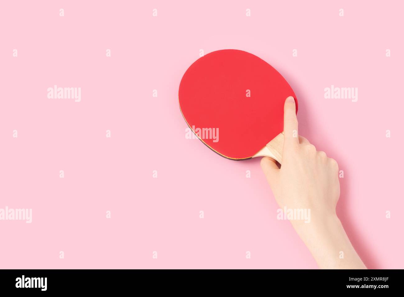 Female hand hold racket for ping pong on a pink background. Composition ...