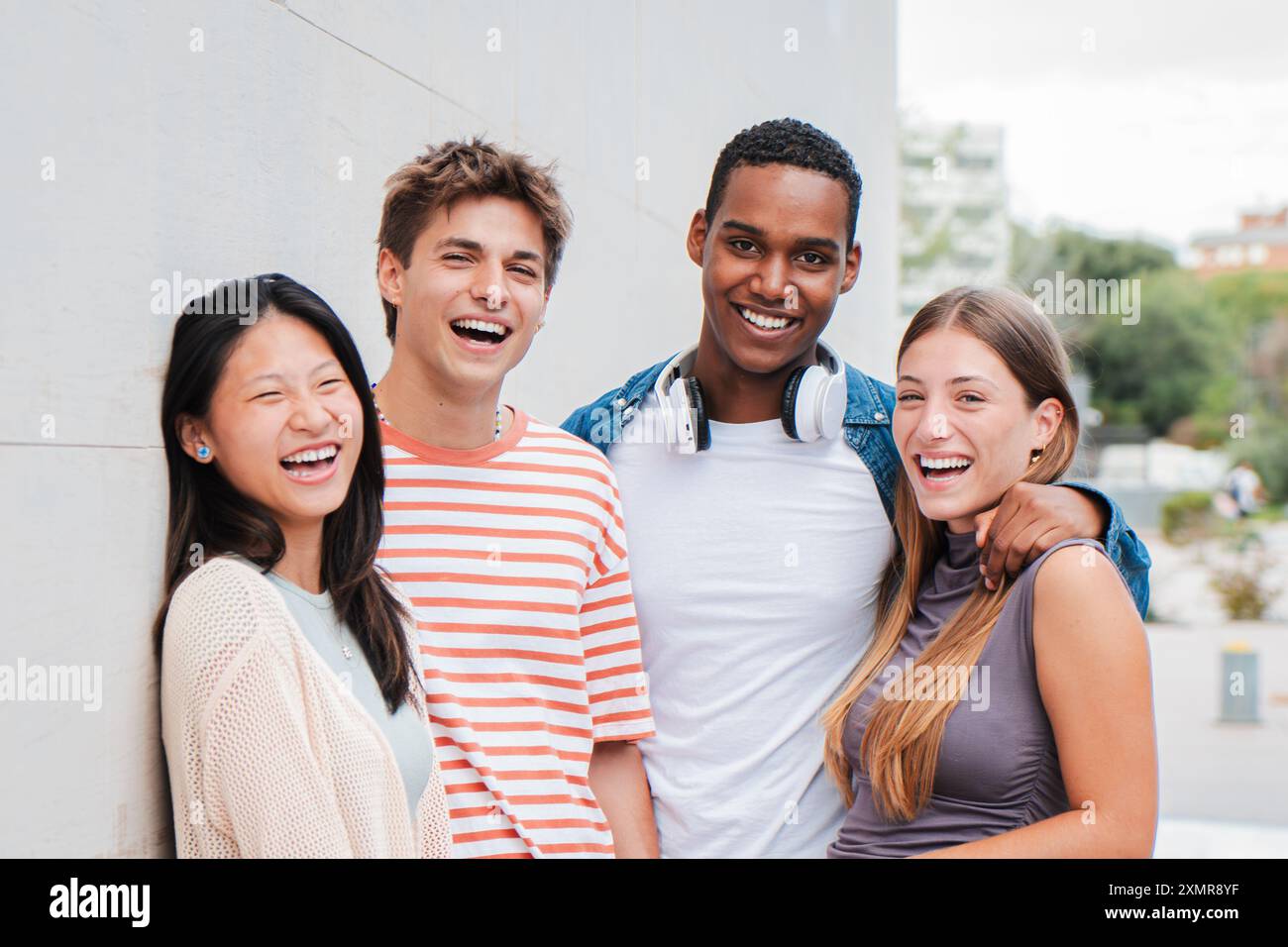two handsome men and two teenage women looking at camera standing at ...