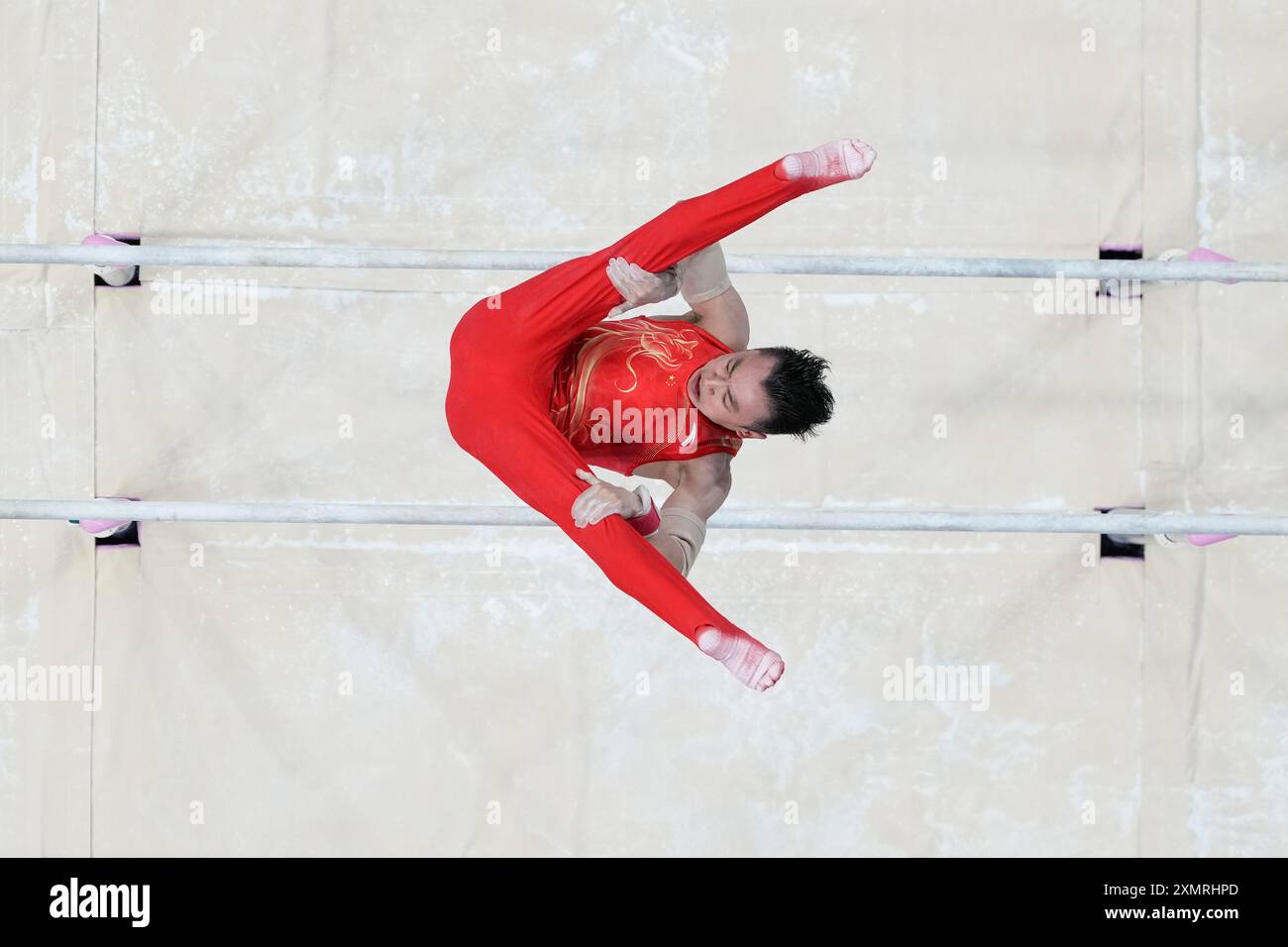 Zou Jingyuan of China performs on the parallel bars during the men's ...