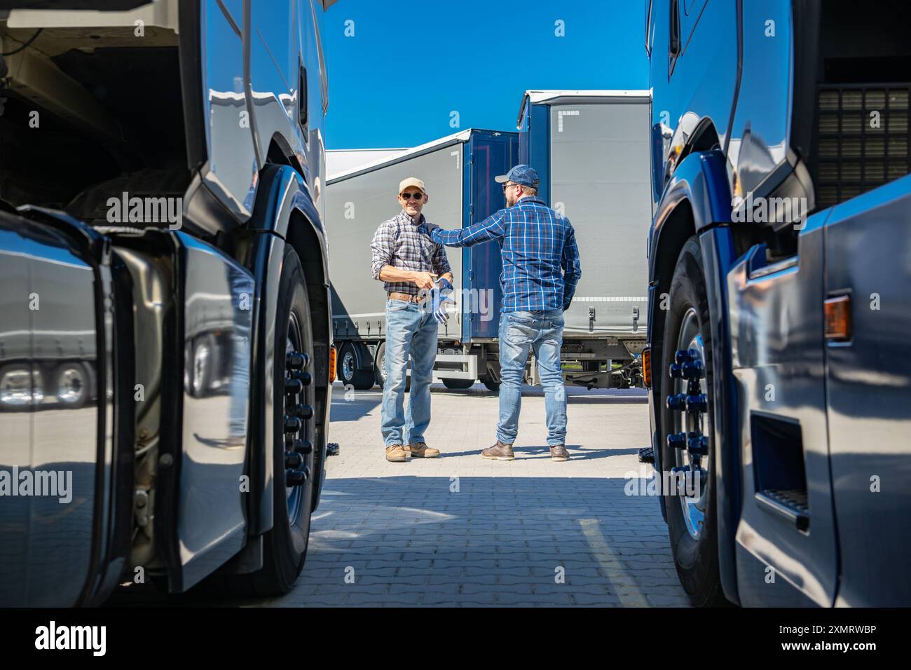 Two truck drivers engage in a conversation about logistics while ...