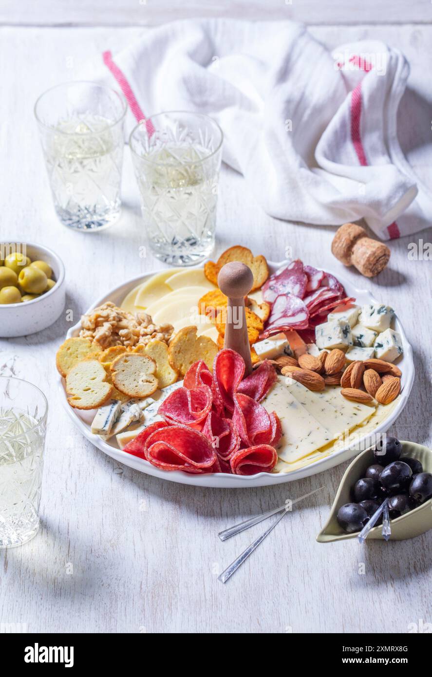 Aperitif, champagne and snack of sausage, cheese, nuts, olives and ...